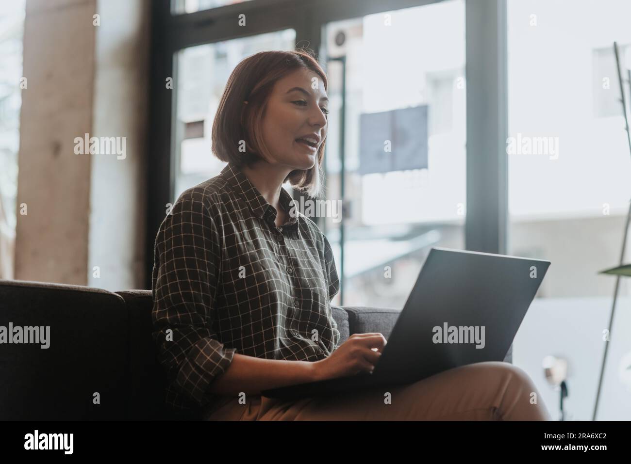 Girl talking to her colleague while working on the lap top Stock Photo ...