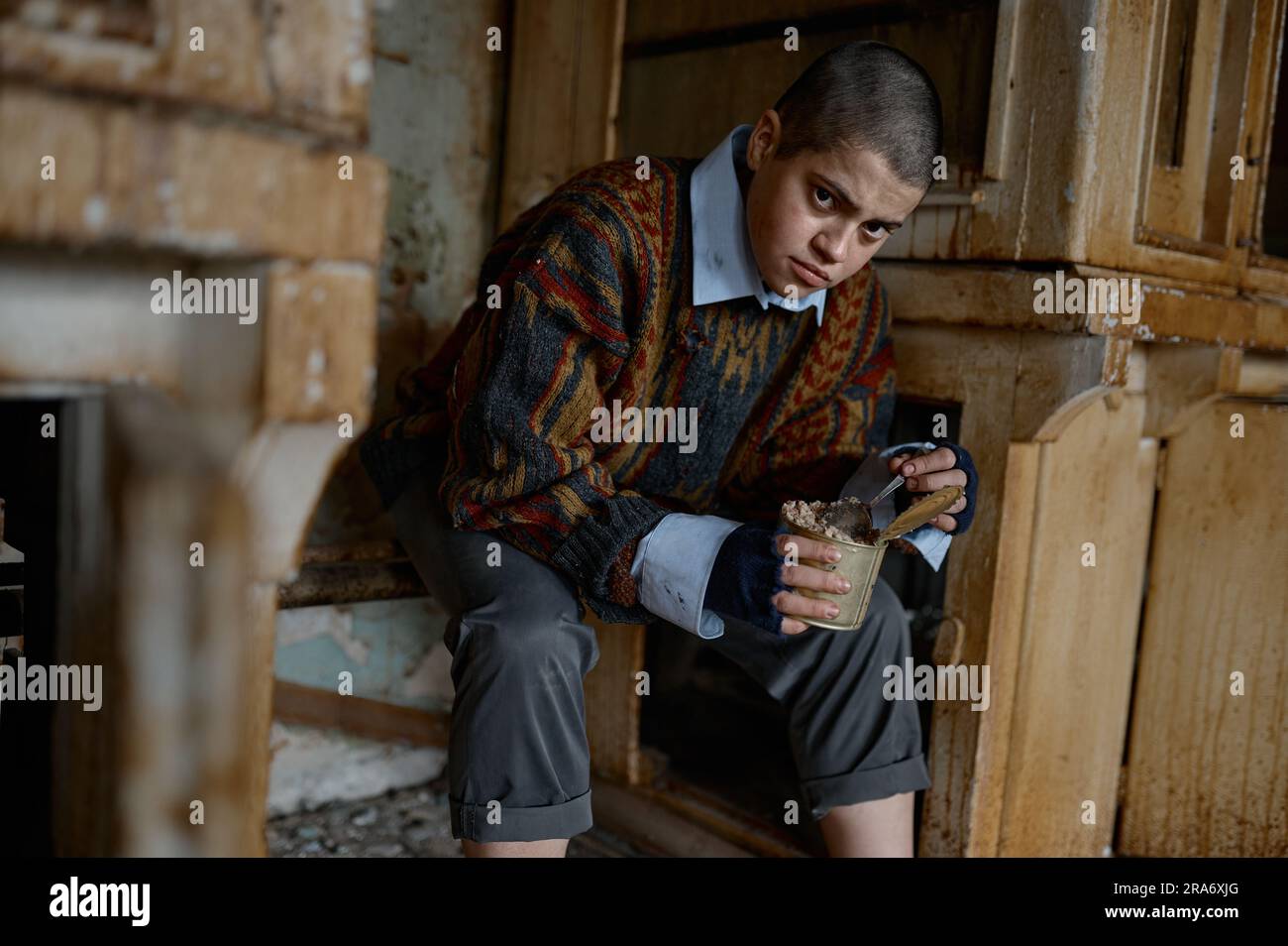 Poor homeless punk woman with sad look eating preserved food Stock ...