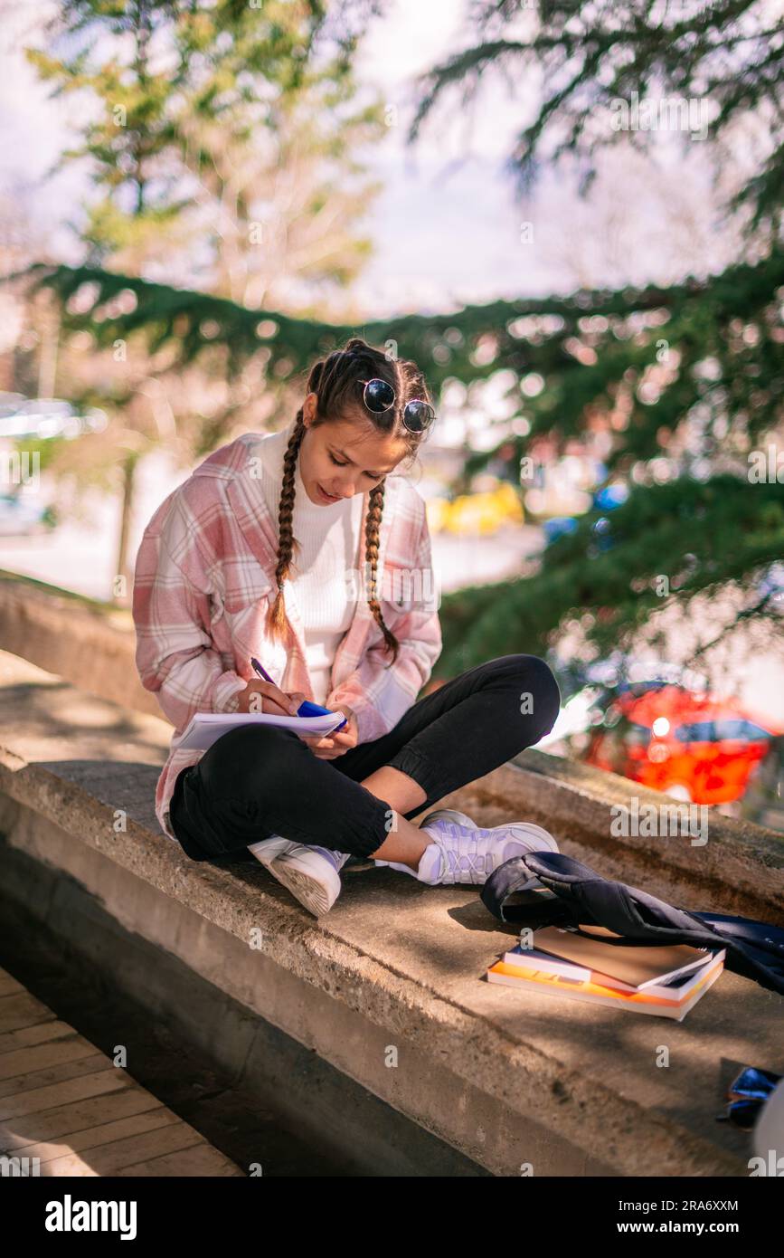 Brunette school girl doing math homework. She is using calculator Stock ...
