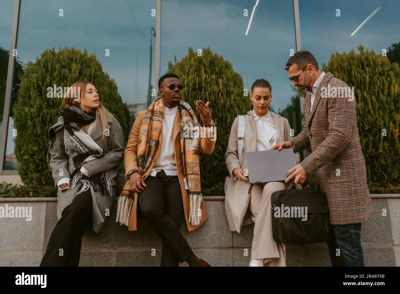 Handsome business man explaining something to his colleagues while ...