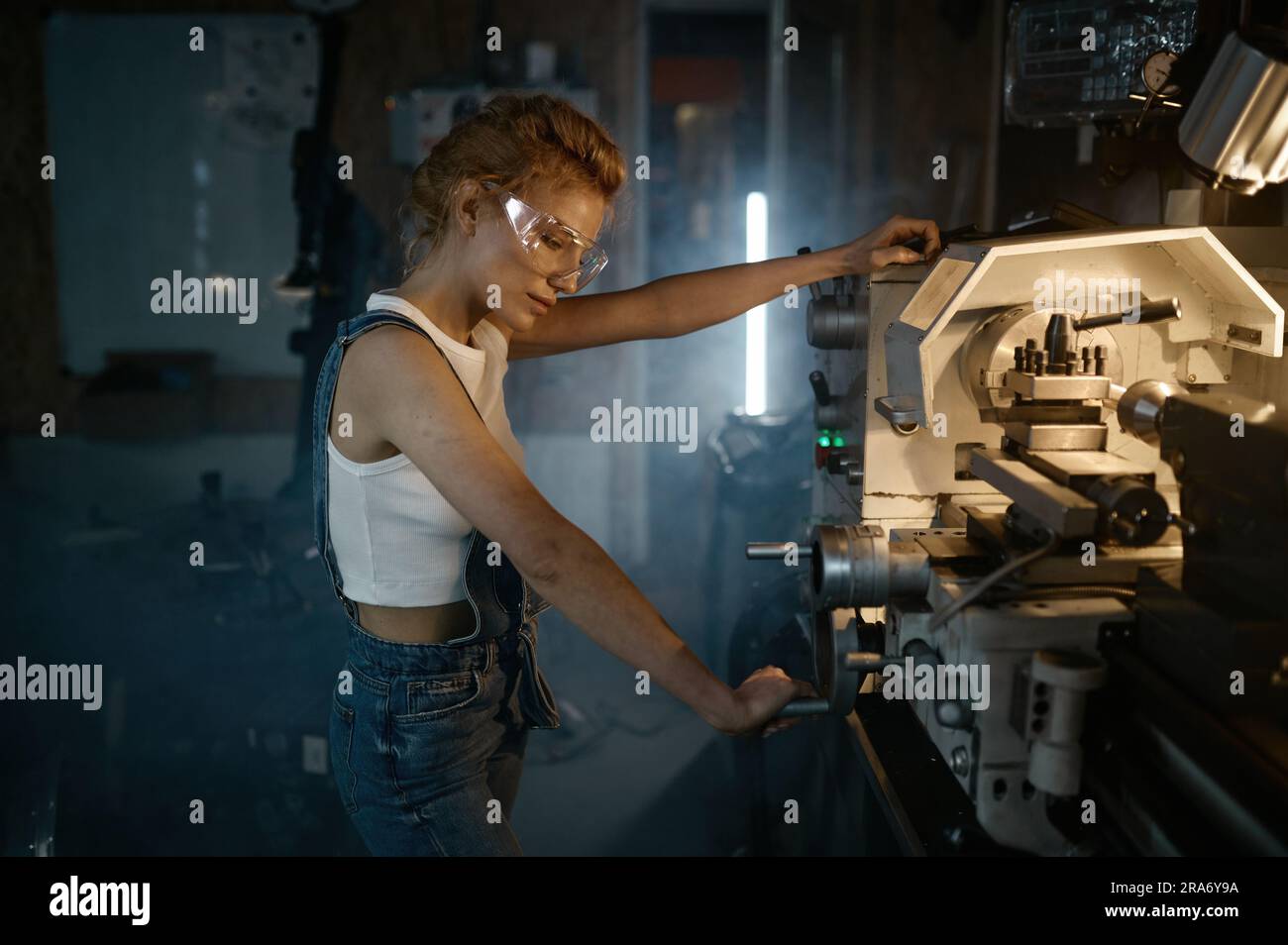 Young blond woman mechanical engineer working on lathe machine Stock ...