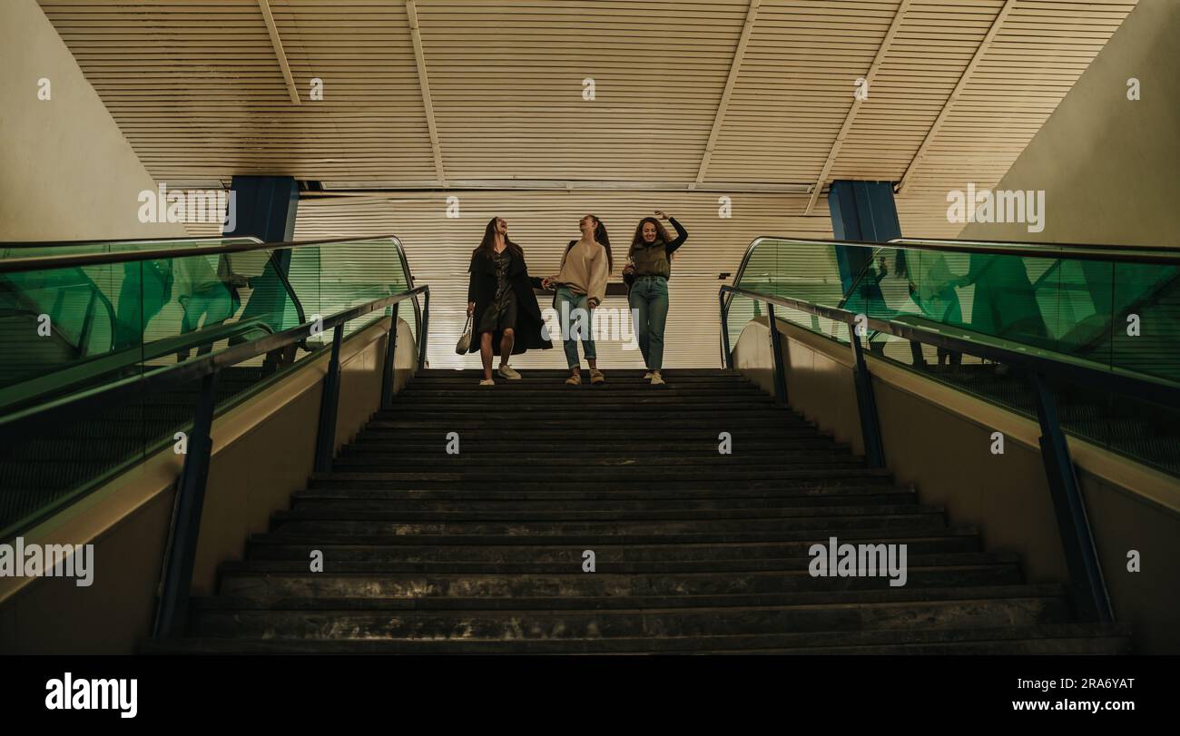 Front view shot of three girls walking downstairs. Curly haired girl ...