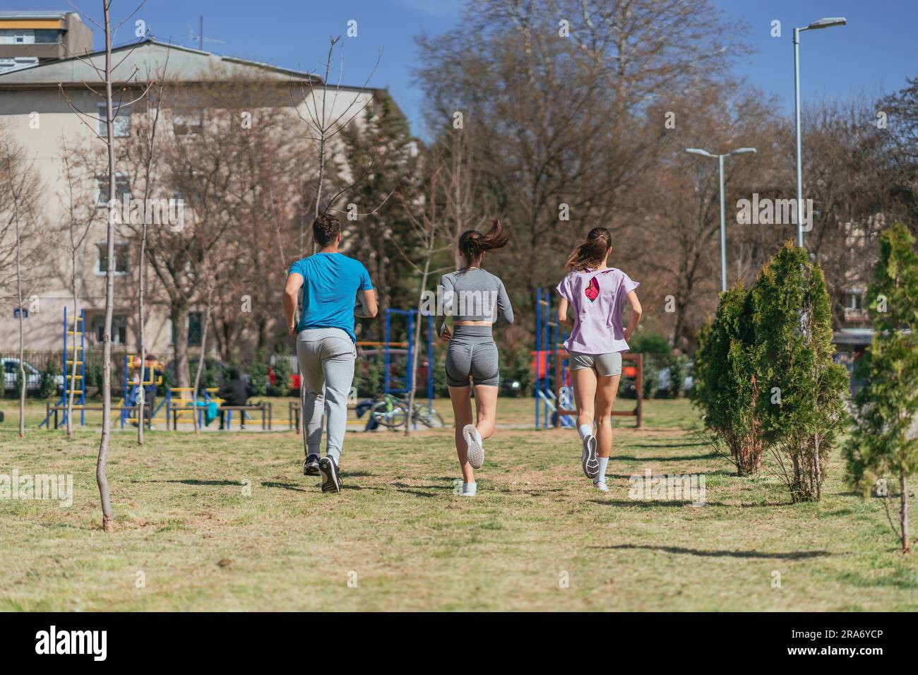 Back view shot of three sports friends running in the park Stock Photo ...