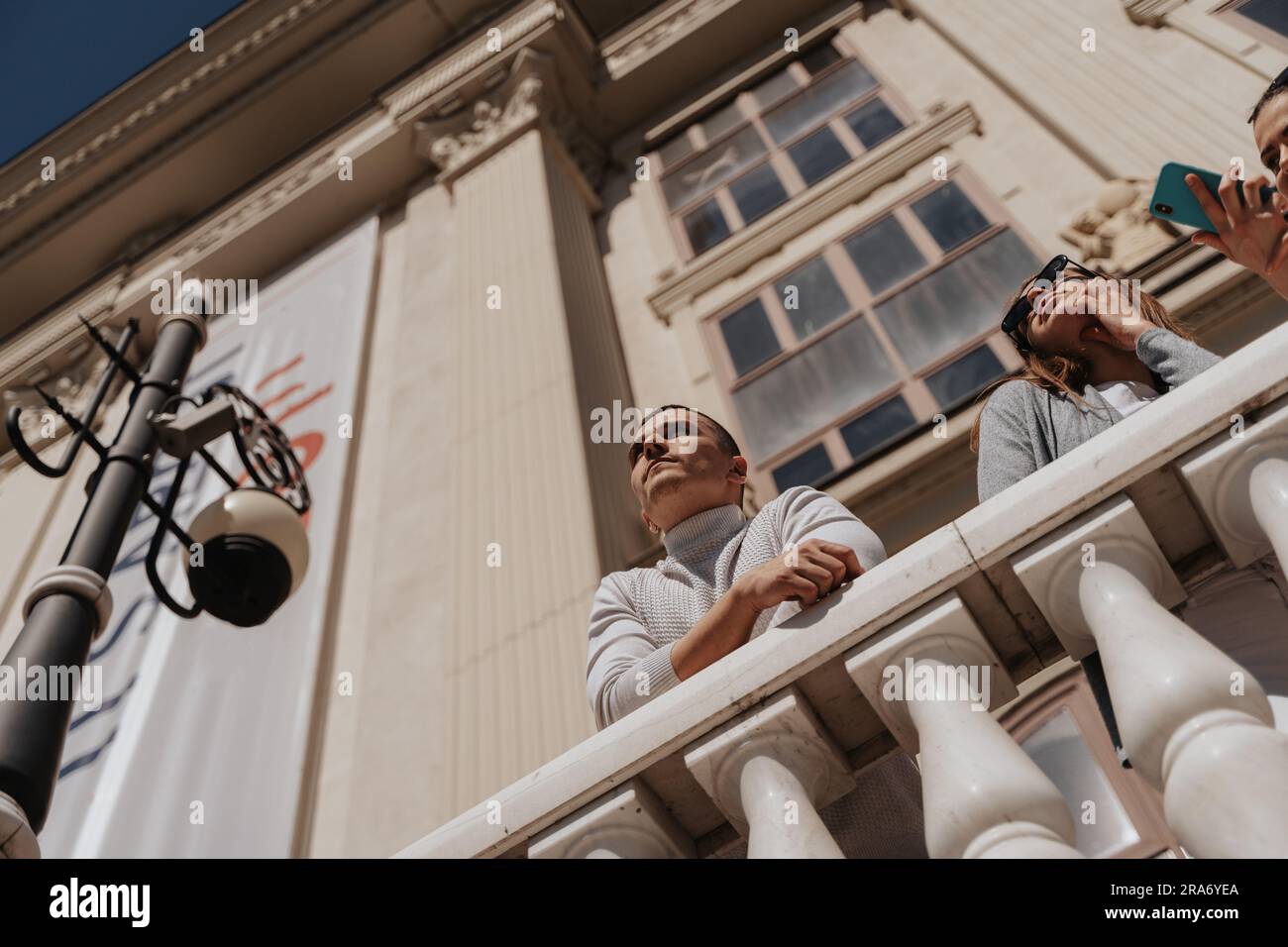 Three friends leaning on the fence while talking and standing in front ...
