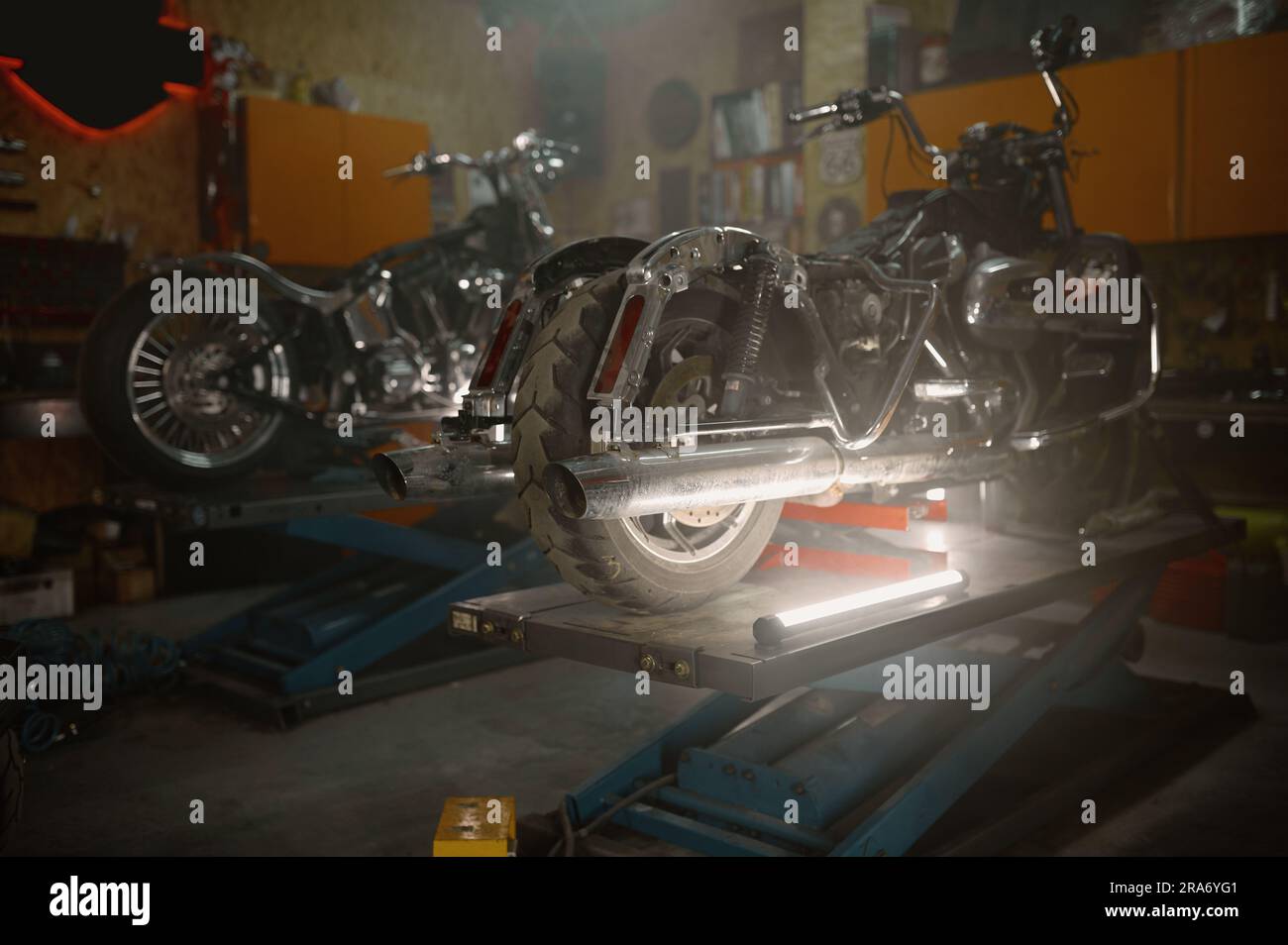 Motorcycles standing on lift machine at vintage repair shop Stock Photo ...
