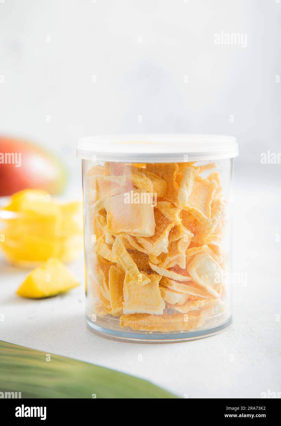 Freeze dried mangoes for cereal in plastic jar on light background ...
