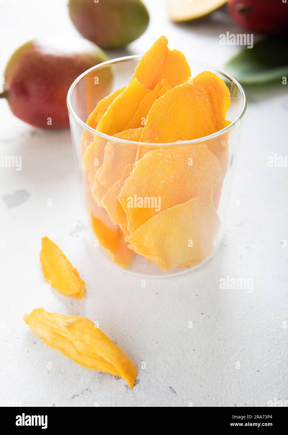Sweet dried mango slices with fresh raw fruits on light background.Top ...