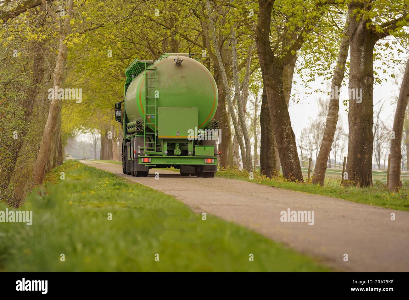 A machine is driving along a country road, rear view. Modern bright ...