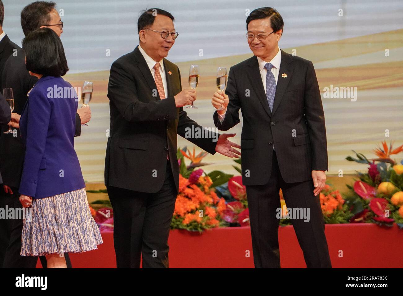 John Lee Ka-chiu (right), holds a glass of wine during the handover ...