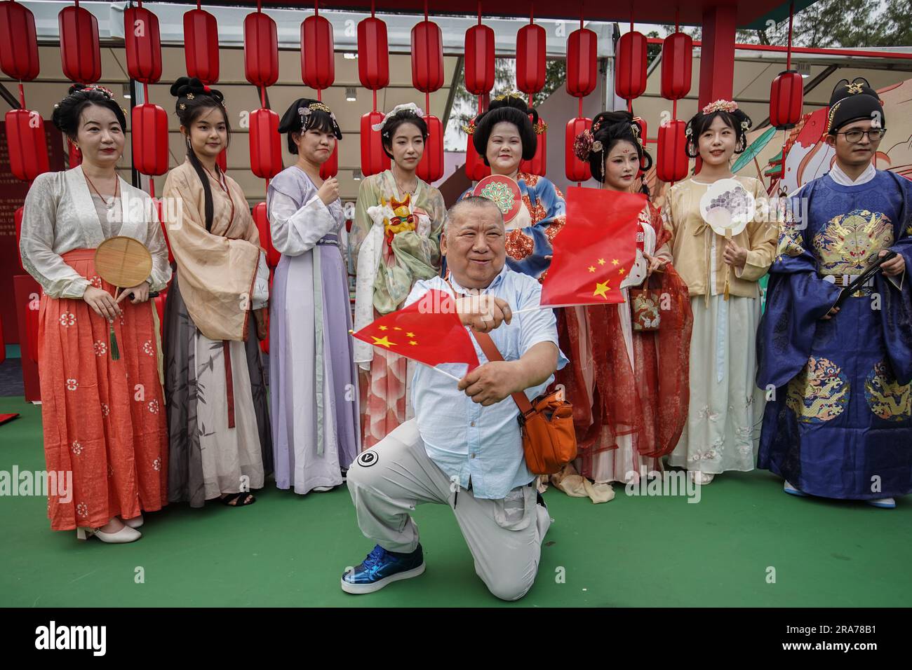 A man waves two flags of China in a handover celebration at Victoria ...