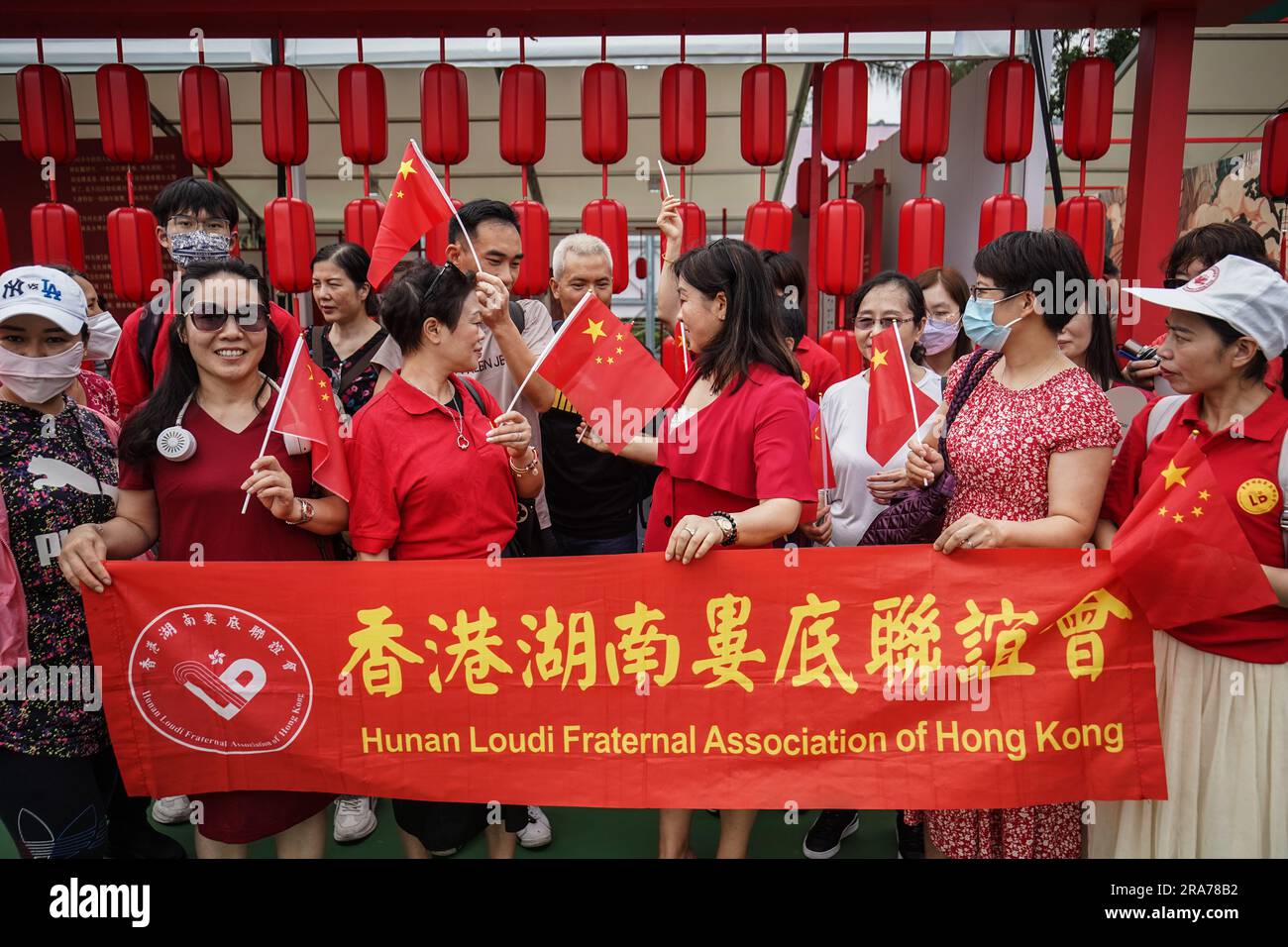 People wave flags of China in a handover celebration at Victoria Park ...