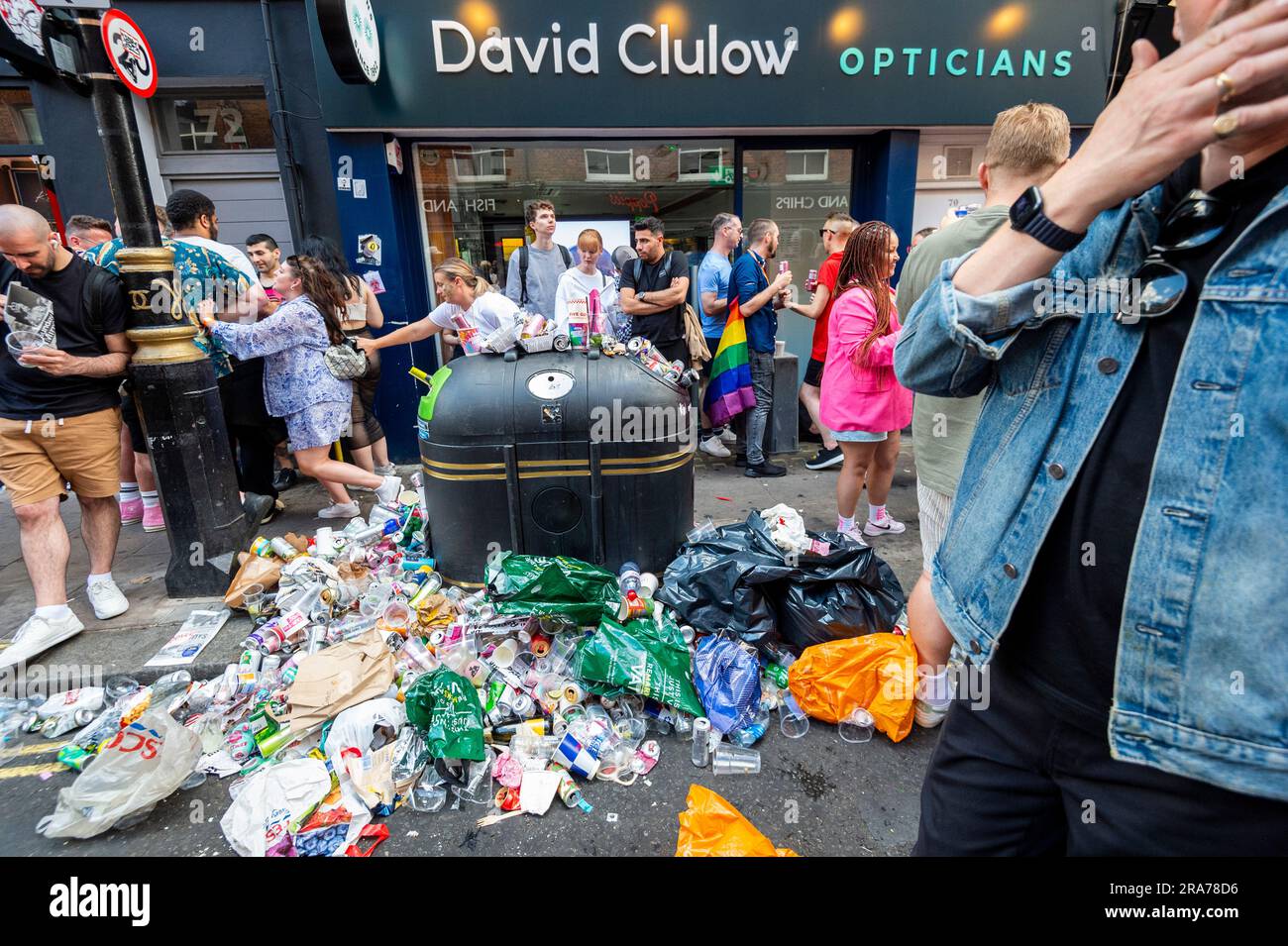 London, UK. 1 July 2023. Revellers in Soho negotiate discarded litter ...