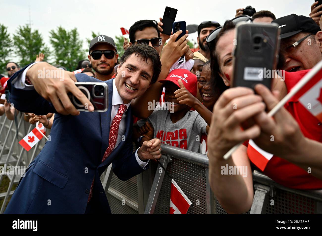 Prime Minister Justin Trudeau takes a selfie using the cellphone of a ...