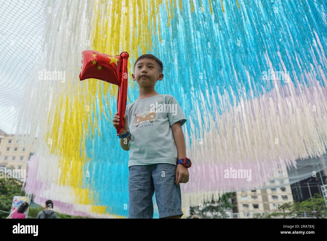 A child holds a balloon that prints a flag of China during a handover ...