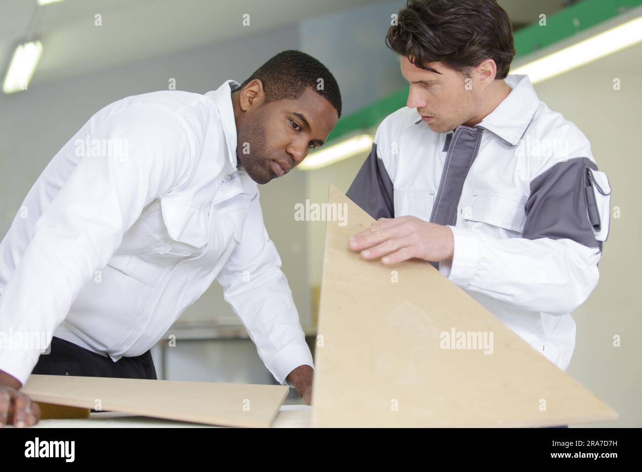 a portrait of two workmen checking wood Stock Photo - Alamy