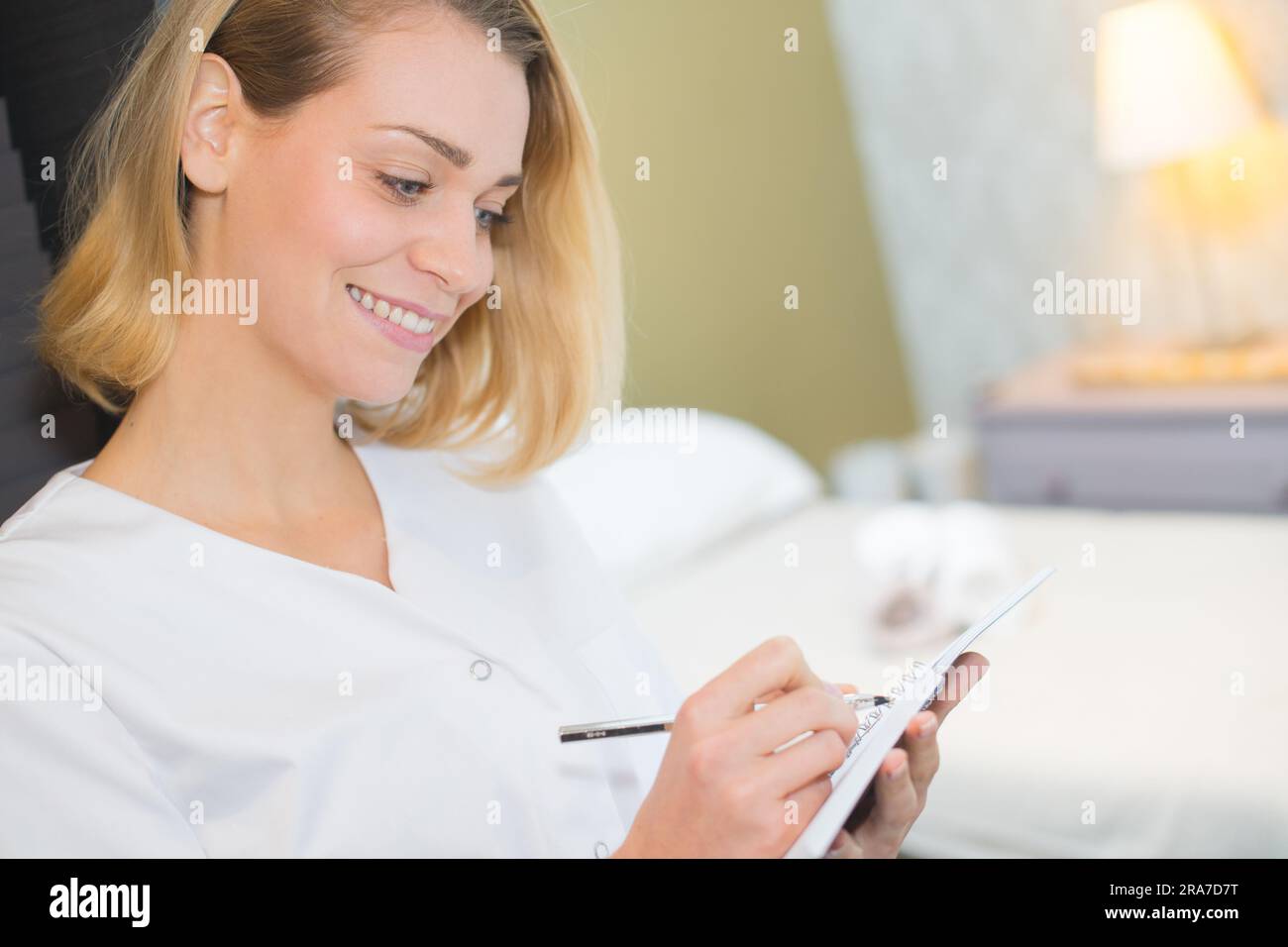 happy pretty young nurse taking notes Stock Photo - Alamy