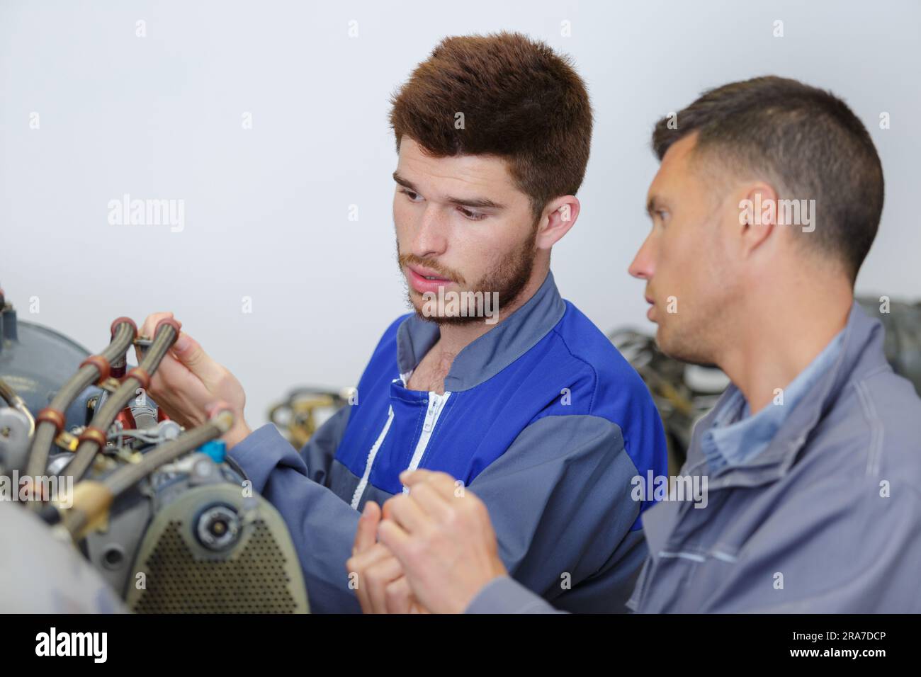 teacher helping students training to be car mechanics Stock Photo - Alamy