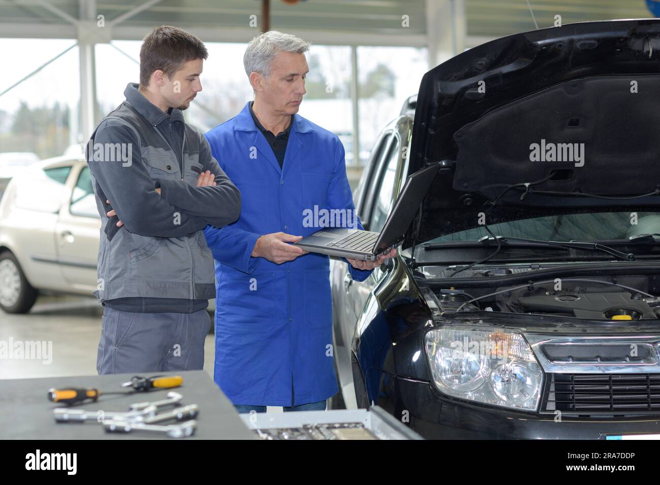 mechanic helping apprentice to fix engine Stock Photo - Alamy