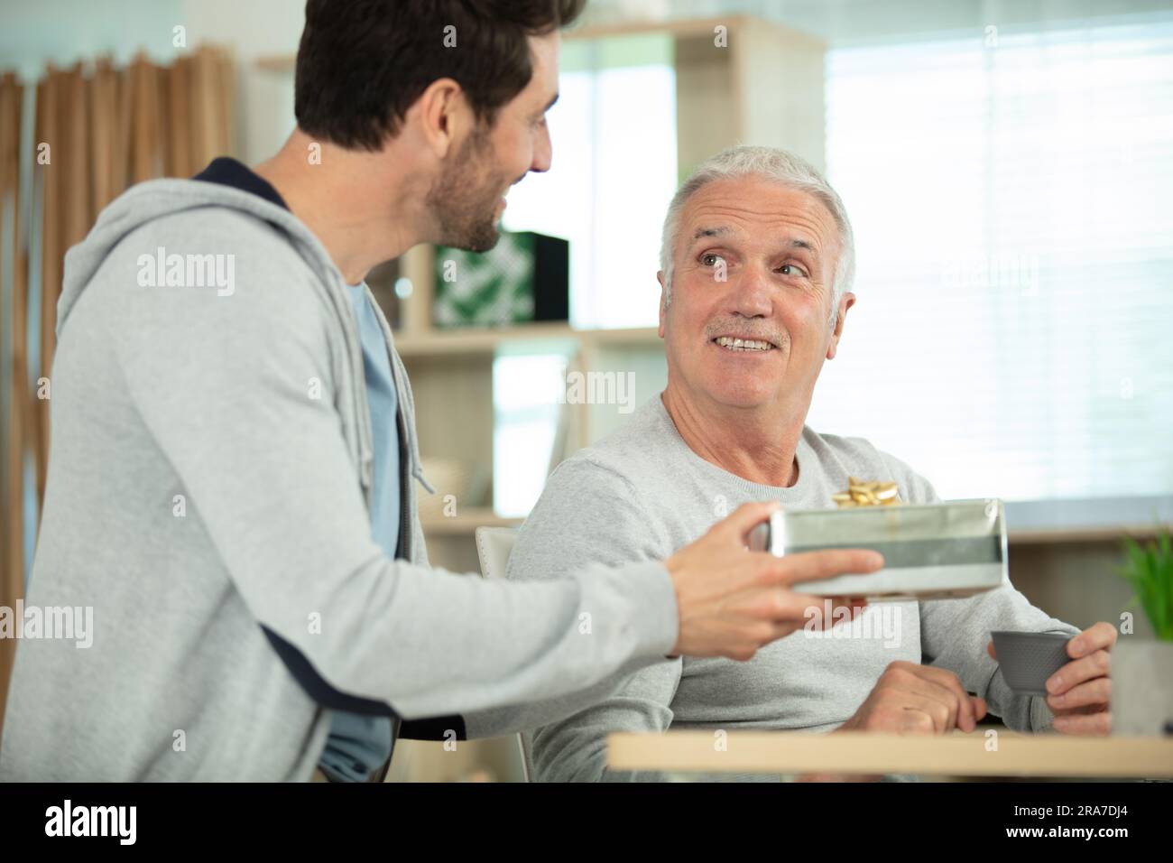 mature son congratulating elderly father Stock Photo - Alamy