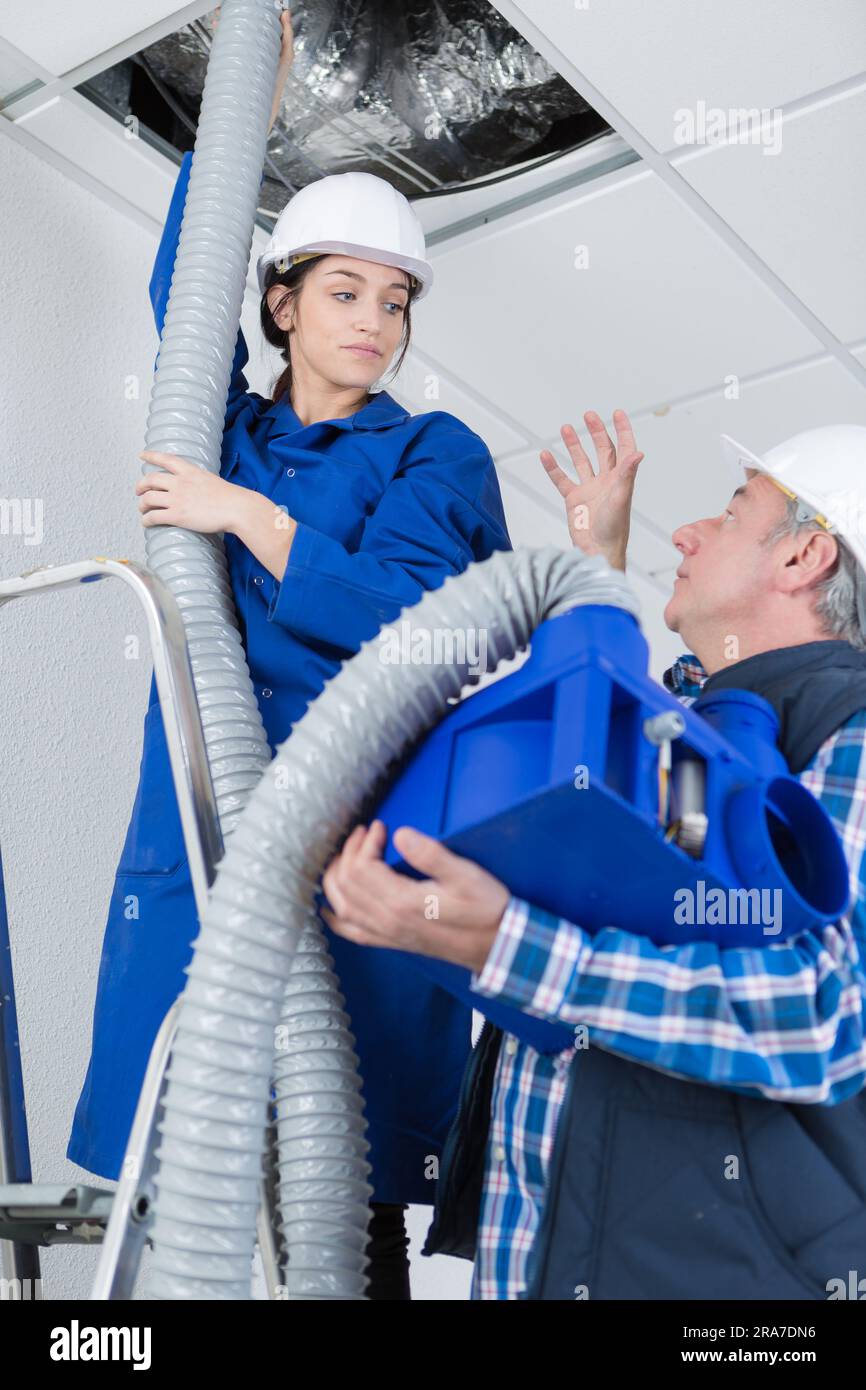 female worker installing pipes in a new house Stock Photo - Alamy