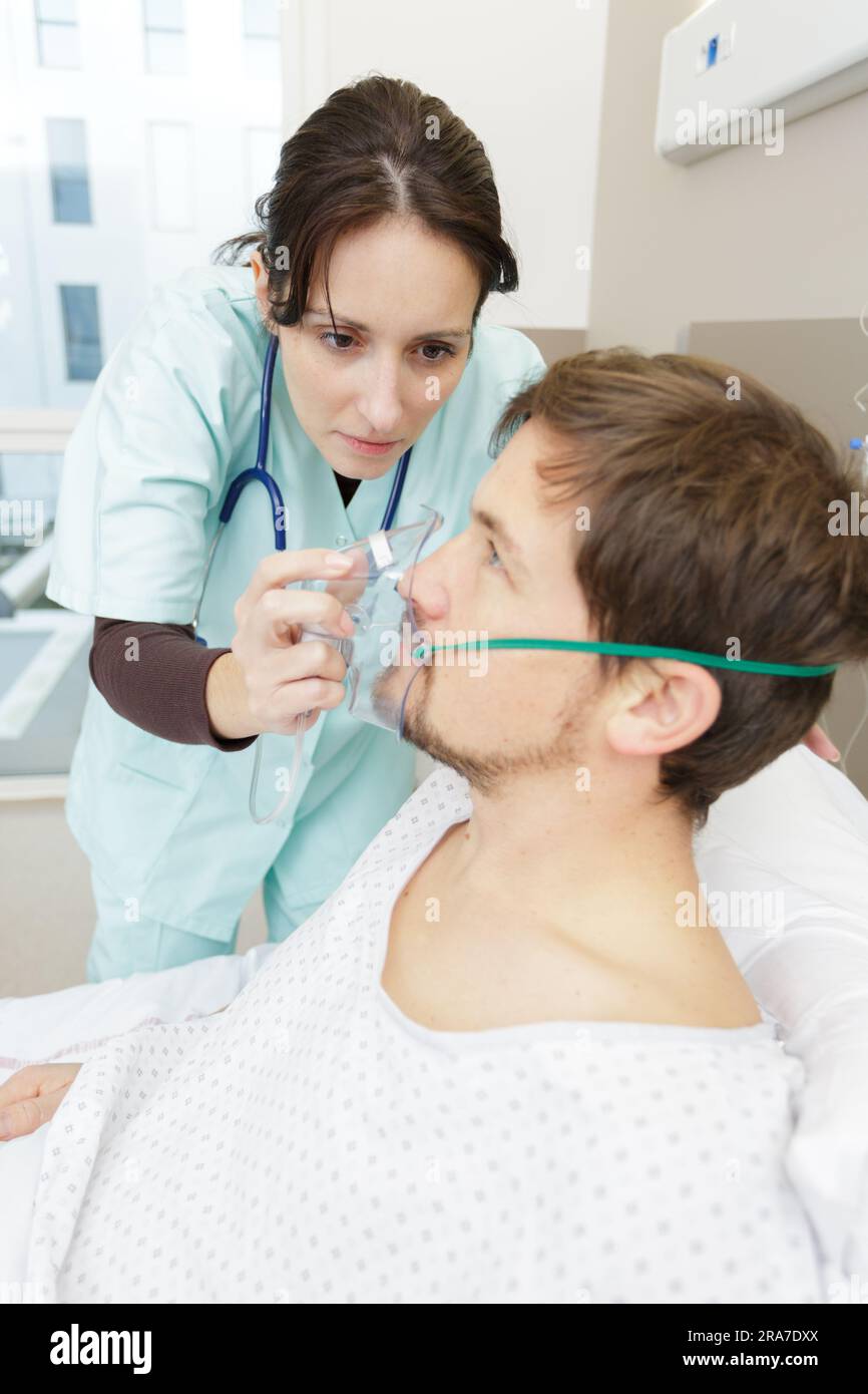 nurse install oxygen mask on patient in hospital room Stock Photo - Alamy