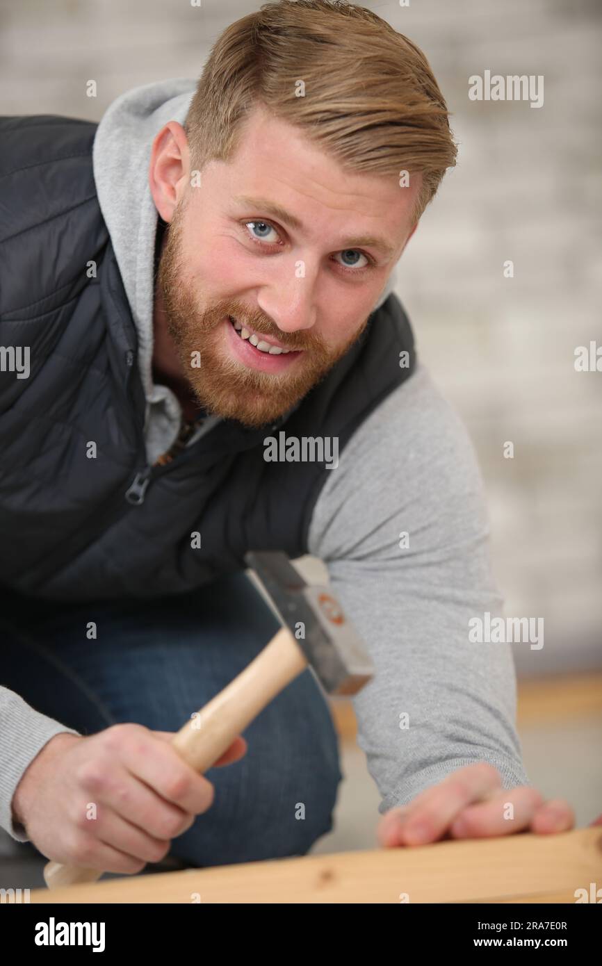 man hammering nail into wood Stock Photo - Alamy