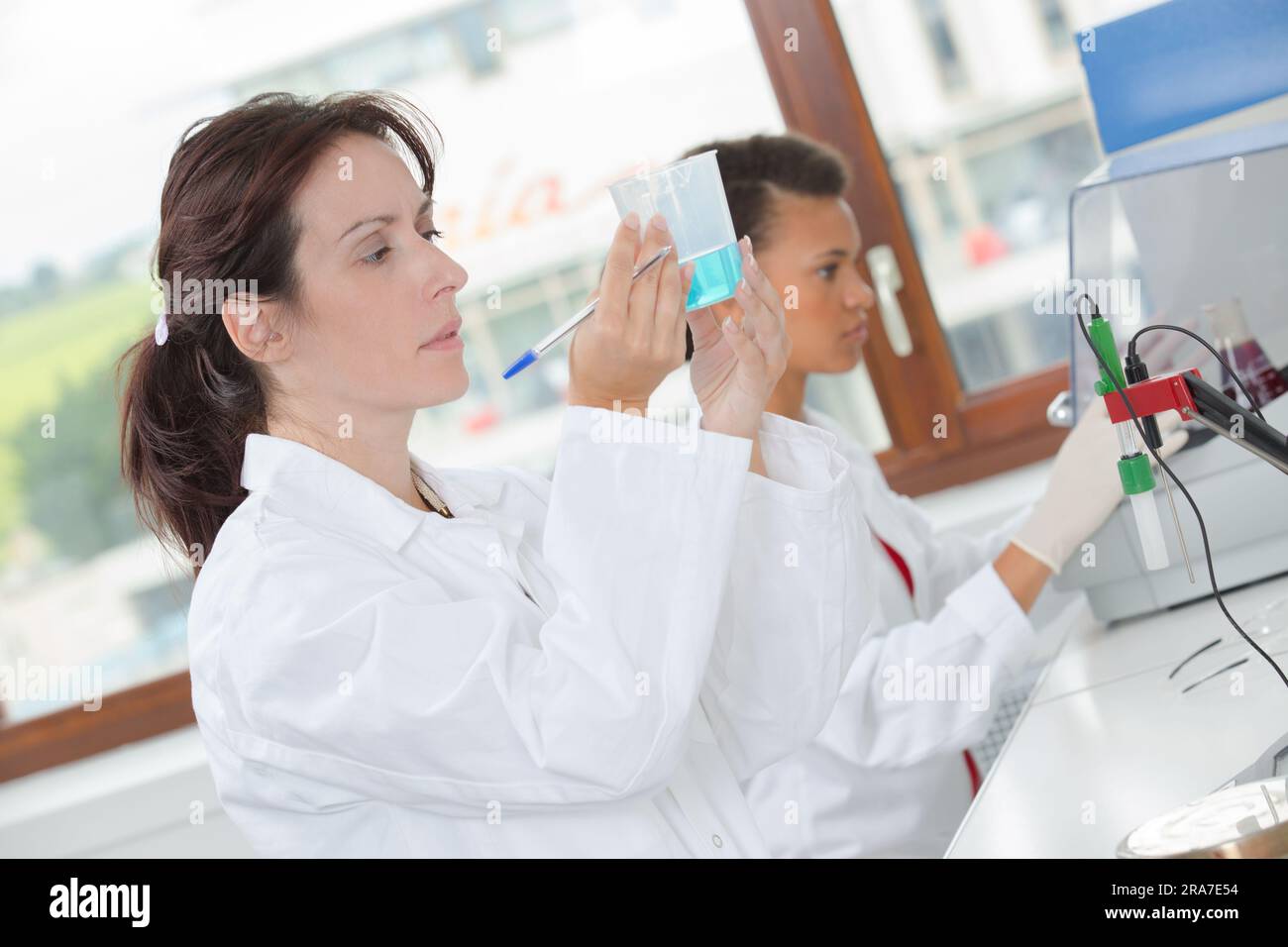 Laboratory worker measuring liquid in beaker Stock Photo - Alamy