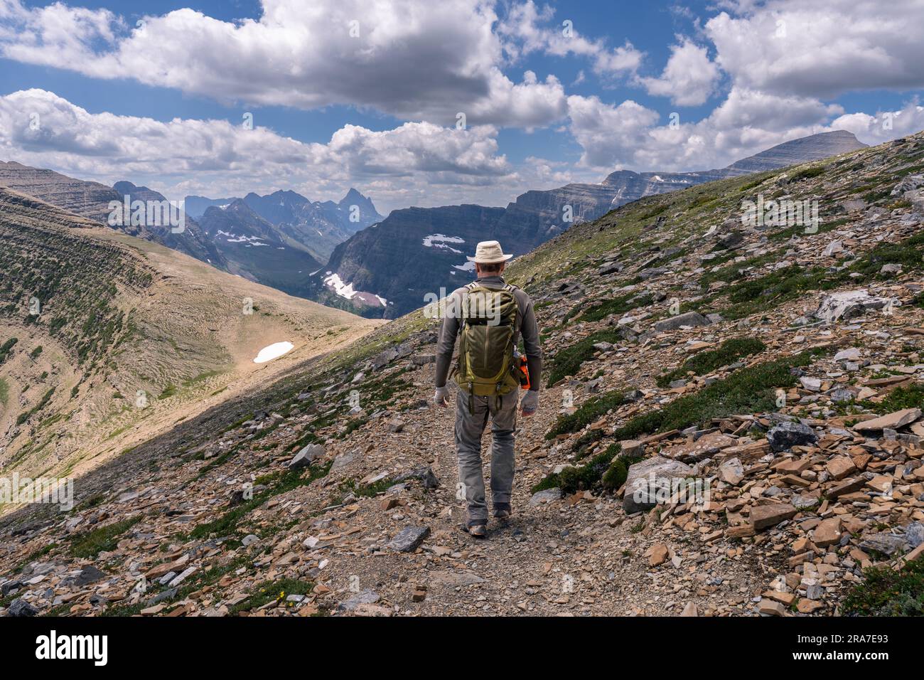 Matured Caucasian man walking down a trail towards a ridge part of a ...