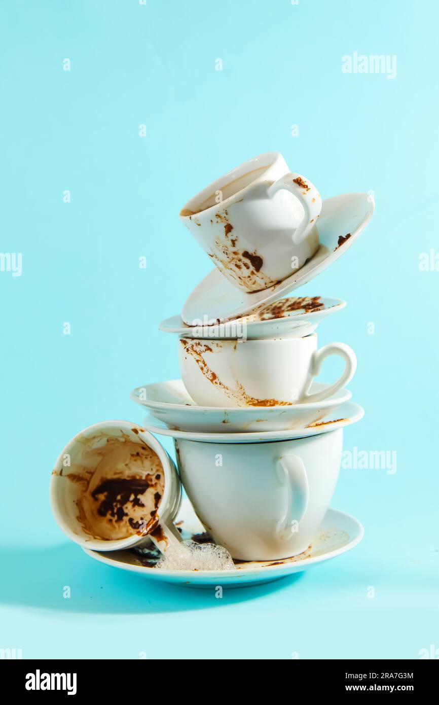 Dirty coffee cups and dish sponges. Blue background Stock Photo - Alamy