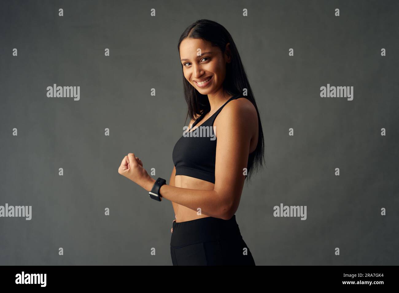 Young biracial woman wearing sports bra and fitness tracker smiling ...