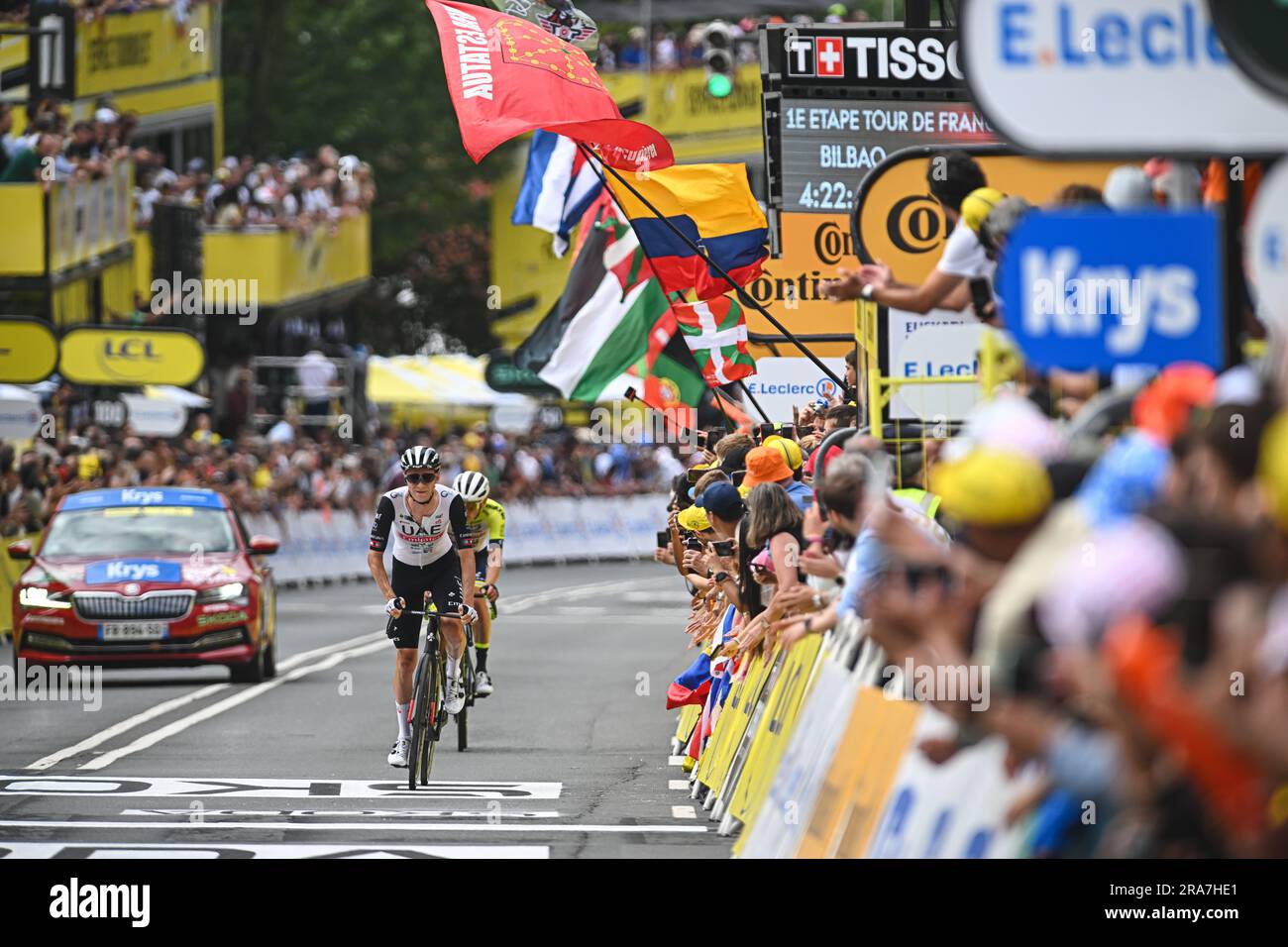 Cyclists entering the finish line lagging behind in a stage of the 2023 ...