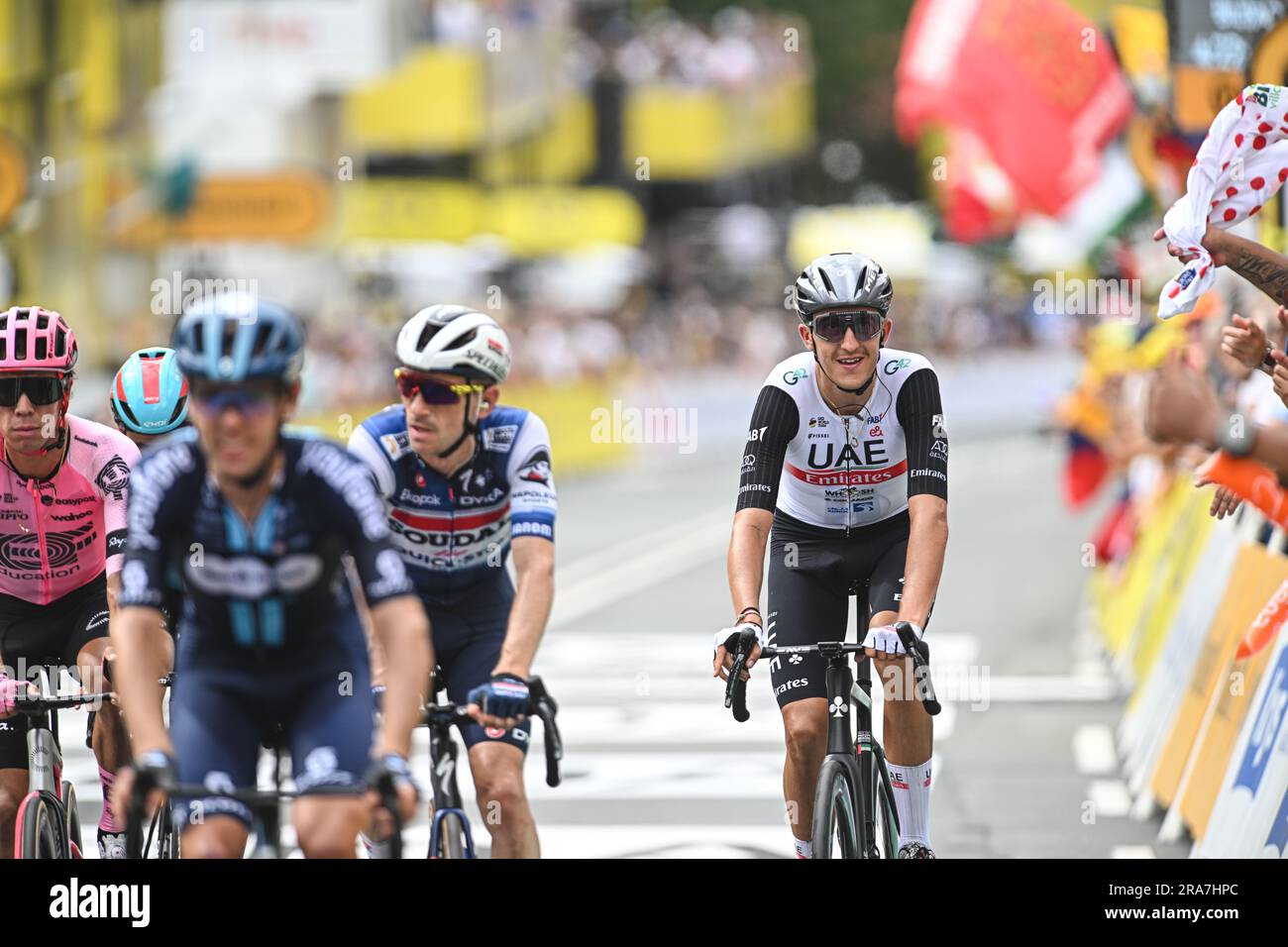 Cyclists entering the finish line lagging behind in a stage of the 2023 ...