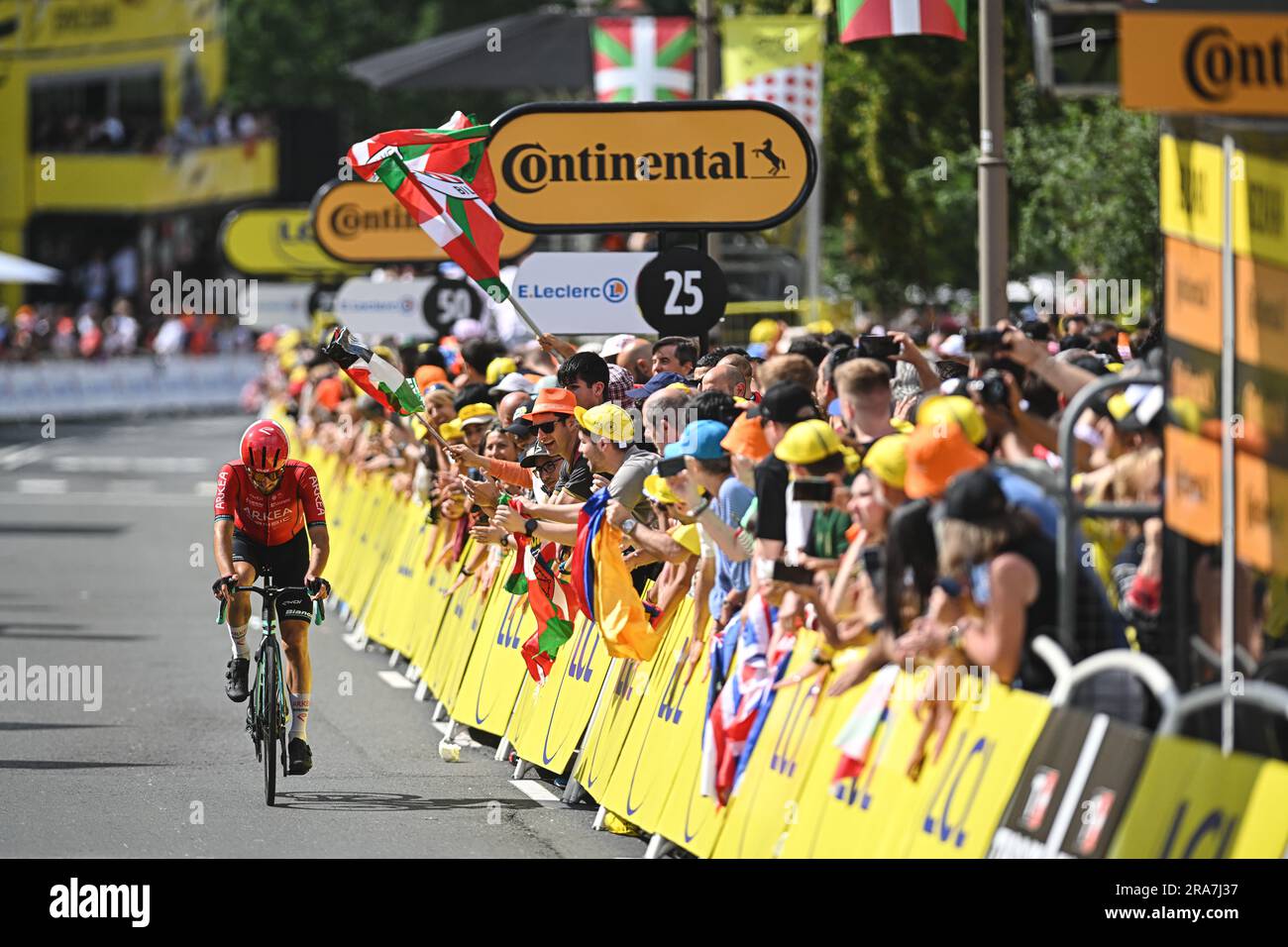 Cyclists entering the finish line lagging behind in a stage of the 2023 ...
