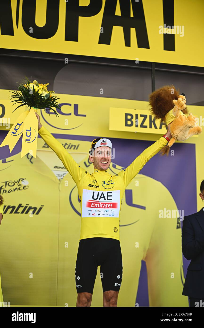 Adam Yates on the podium in Bilbao with the yellow jersey of the leader ...