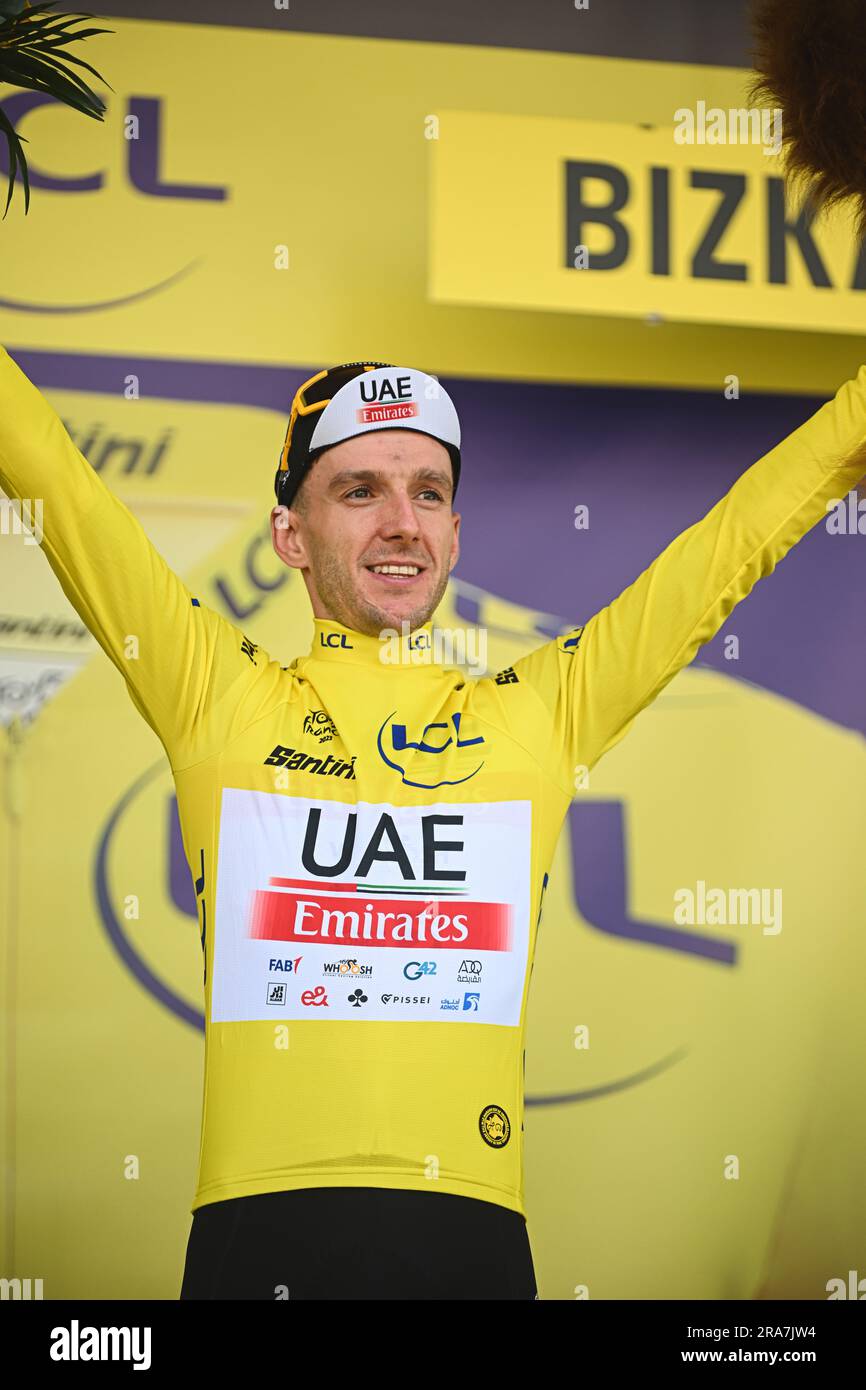 Adam Yates on the podium in Bilbao with the yellow jersey of the leader ...