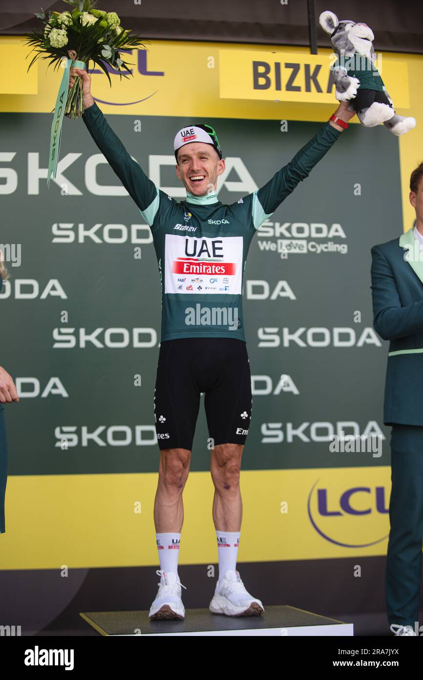 Adam Yates on the podium in Bilbao with the green jersey of the leader ...