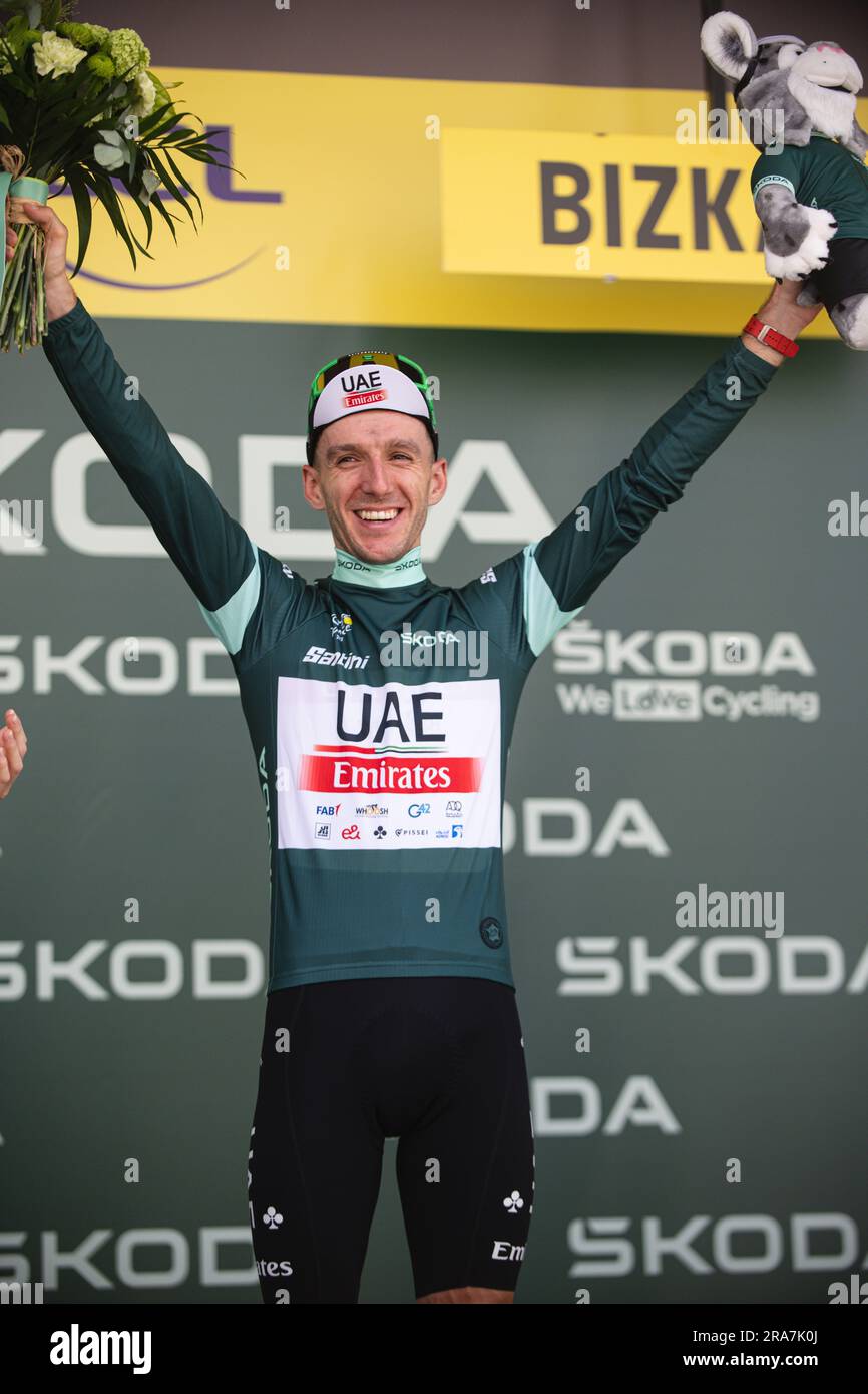 Adam Yates on the podium in Bilbao with the green jersey of the leader ...