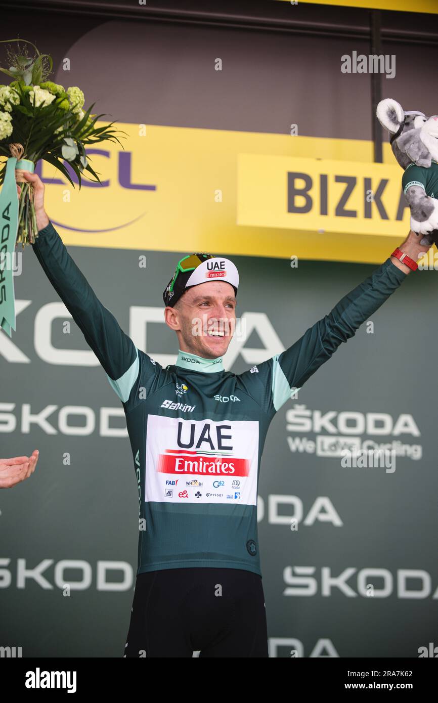Adam Yates on the podium in Bilbao with the green jersey of the leader ...