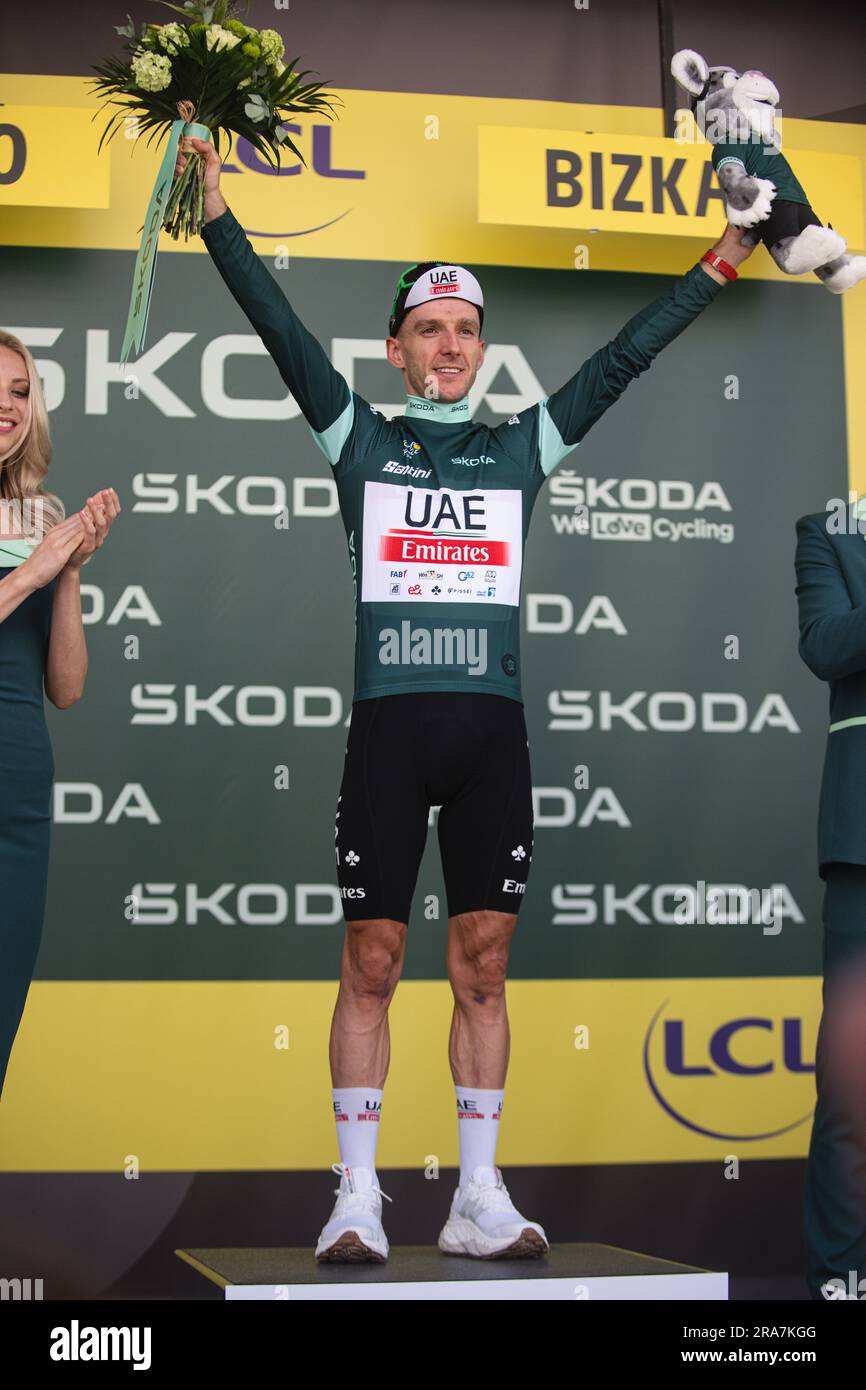 Adam Yates on the podium in Bilbao with the green jersey of the leader ...