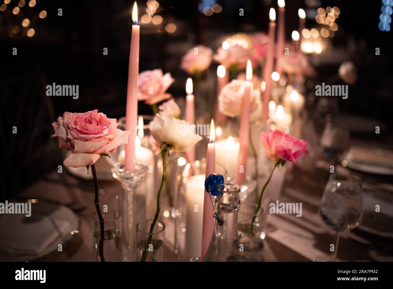 Chivalric wedding with pillars of candles and roses in glass vases ...