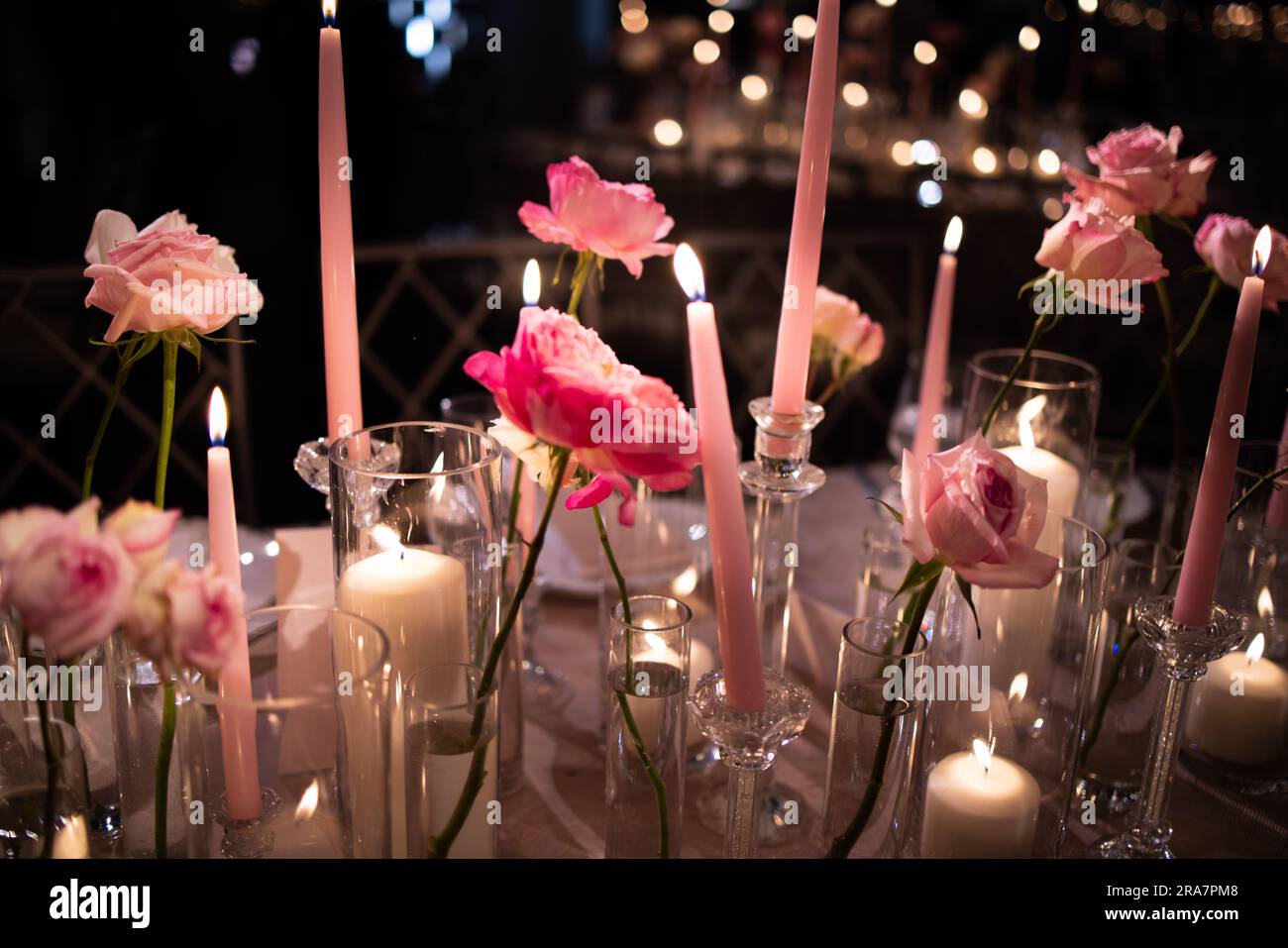 Chivalric wedding with pillars of candles and roses in glass vases ...