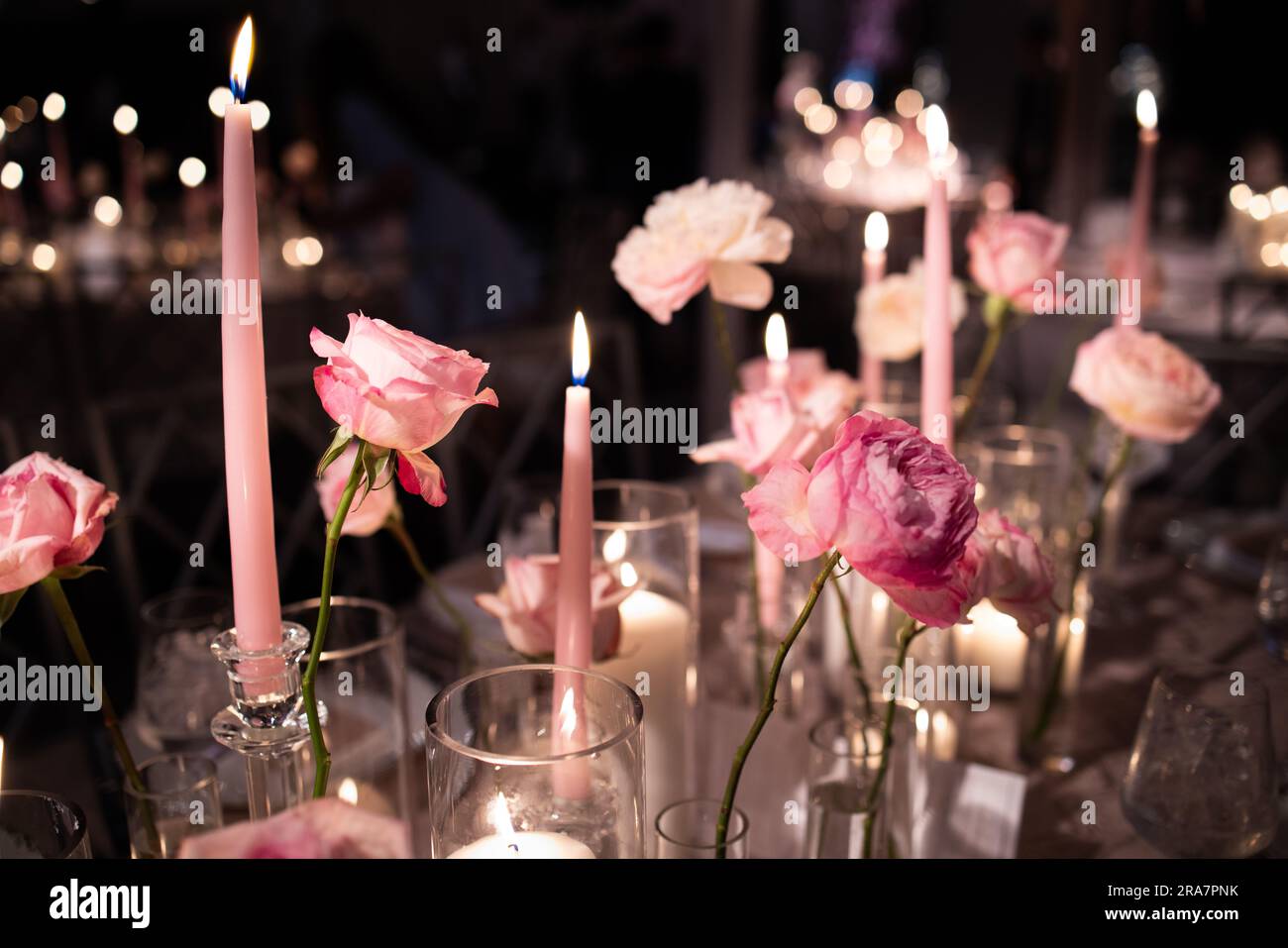 Chivalric wedding with pillars of candles and roses in glass vases ...