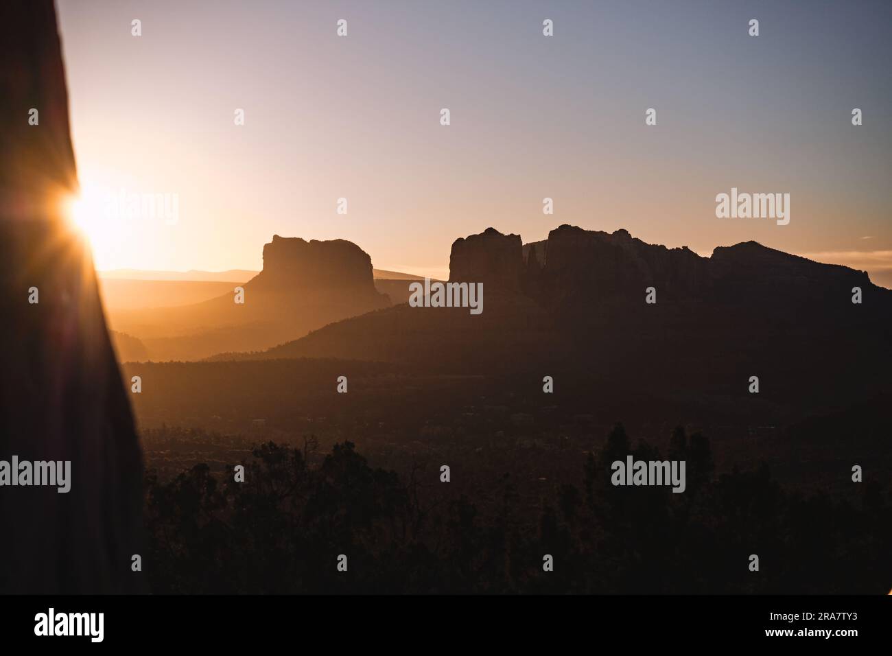 Rising sun - captured as a bright star - lights Sedona's famous rock ...