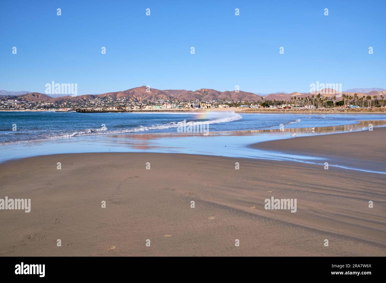 Rainbow appears in spray of breaking wave on sandy beach in Ventura, CA ...