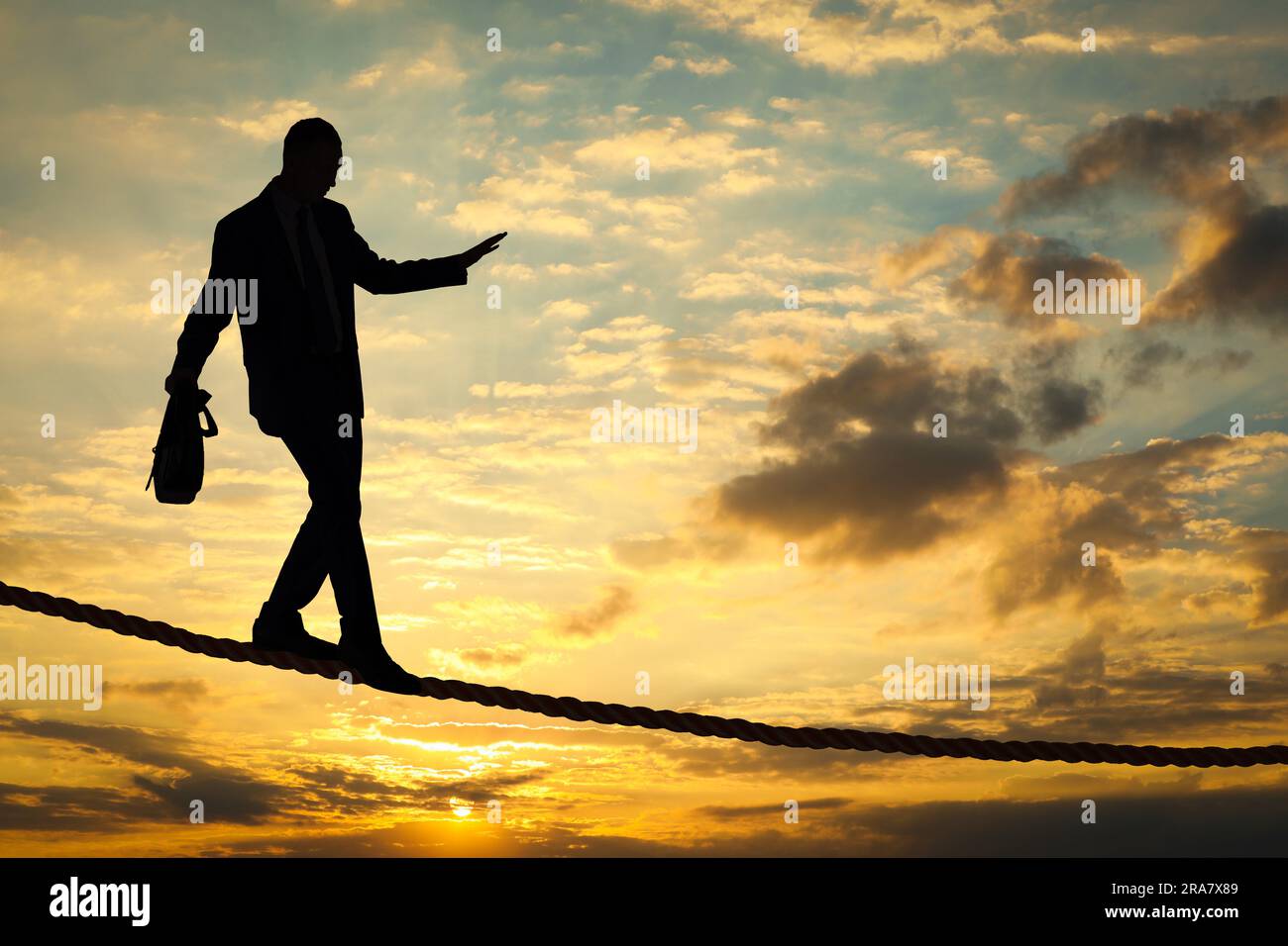 Risks and challenges of owning business. Silhouette of man balancing on ...