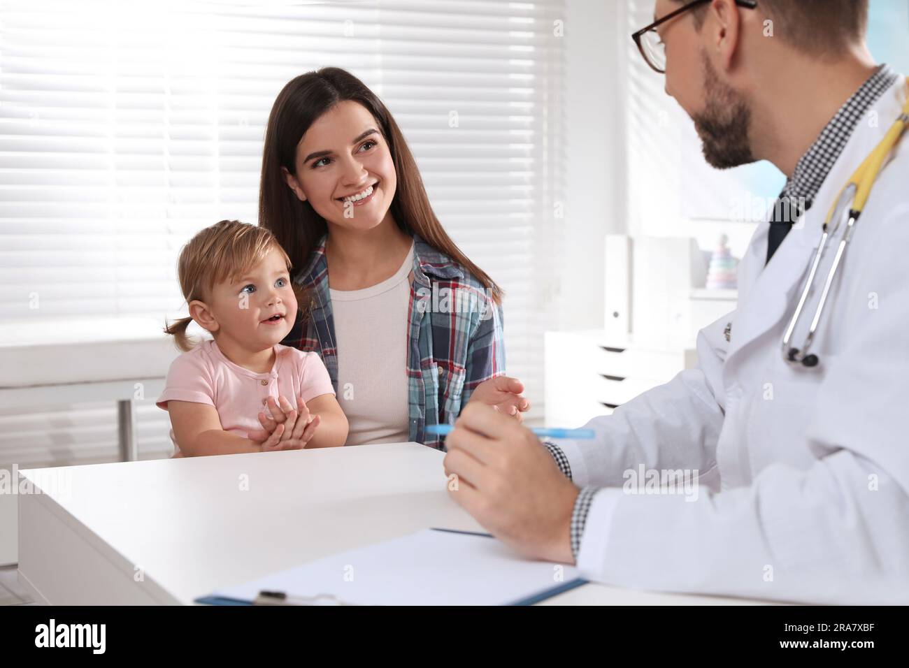 Mother and her cute baby having appointment with pediatrician in clinic ...