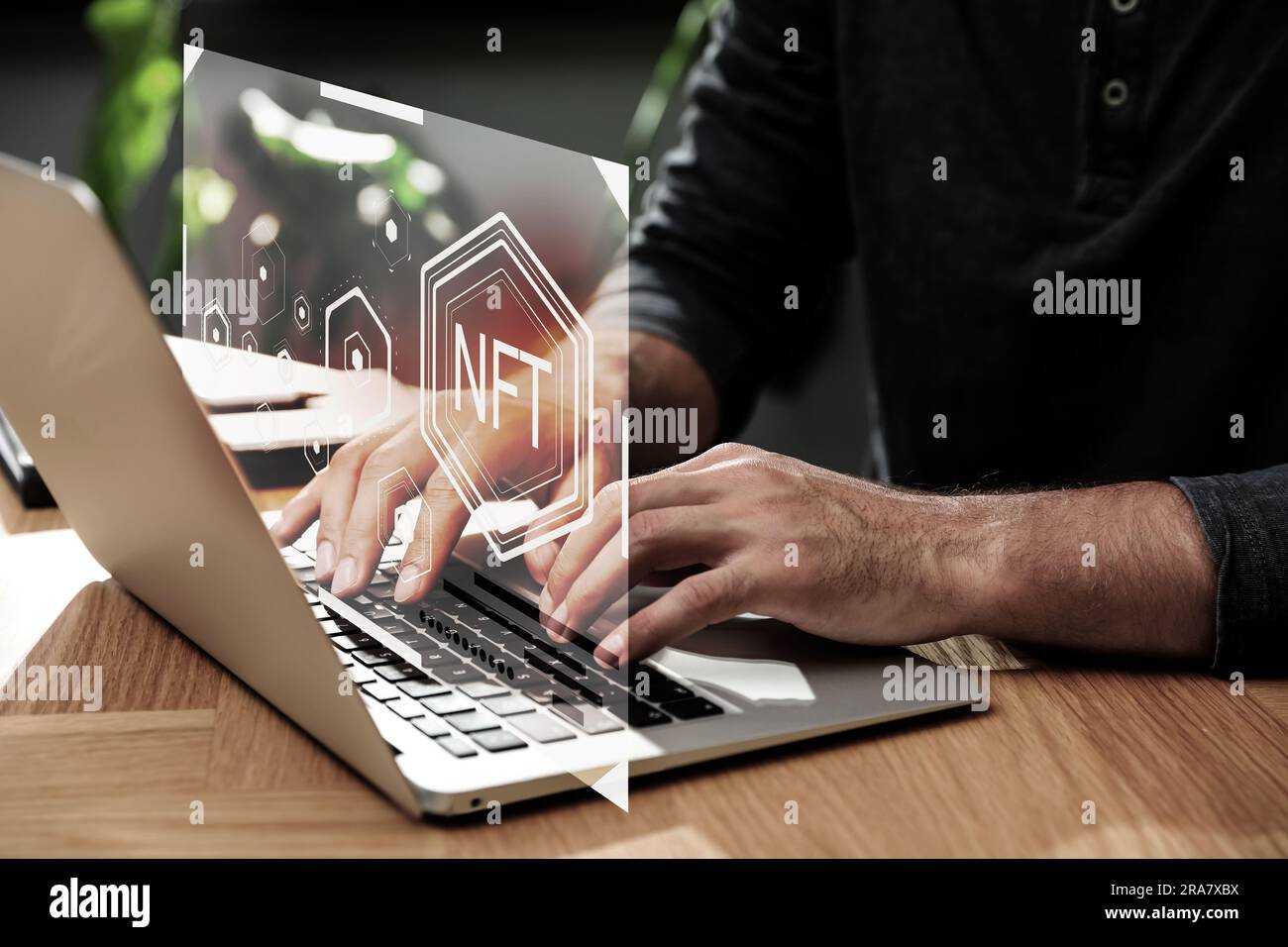Man using laptop at table, closeup. Interface with abbreviation NFT ...