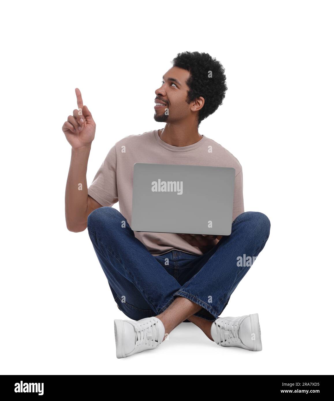 Smiling man with laptop pointing at something on white background Stock ...