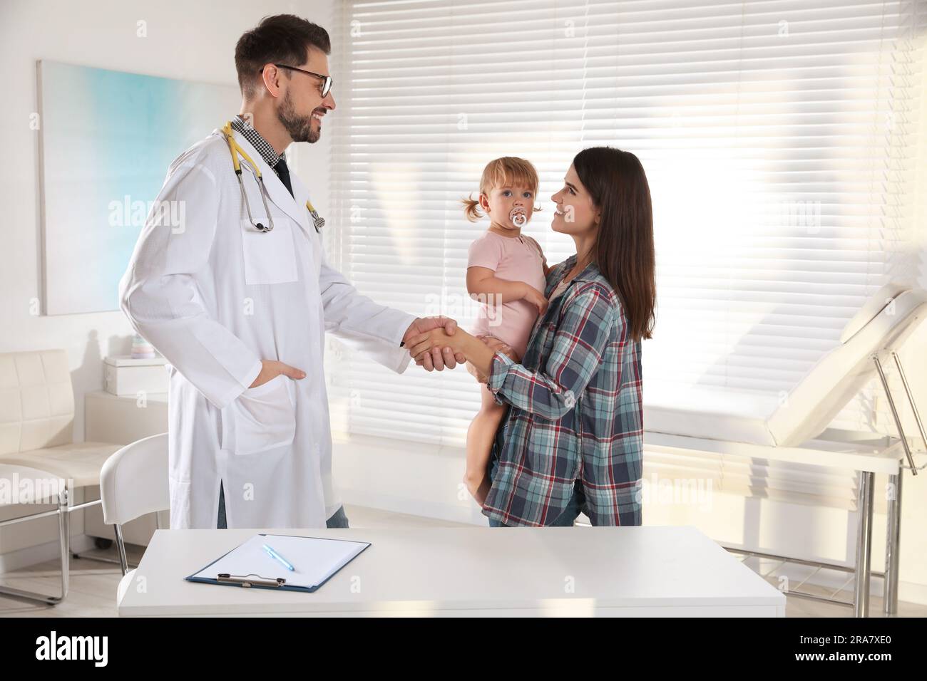 Mother and her cute baby having appointment with pediatrician in clinic ...