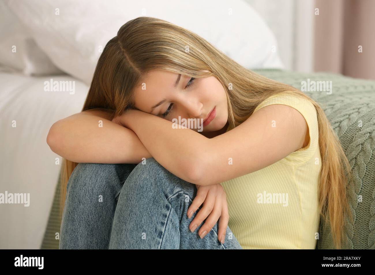 Upset teenage girl sitting alone in room at home Stock Photo - Alamy
